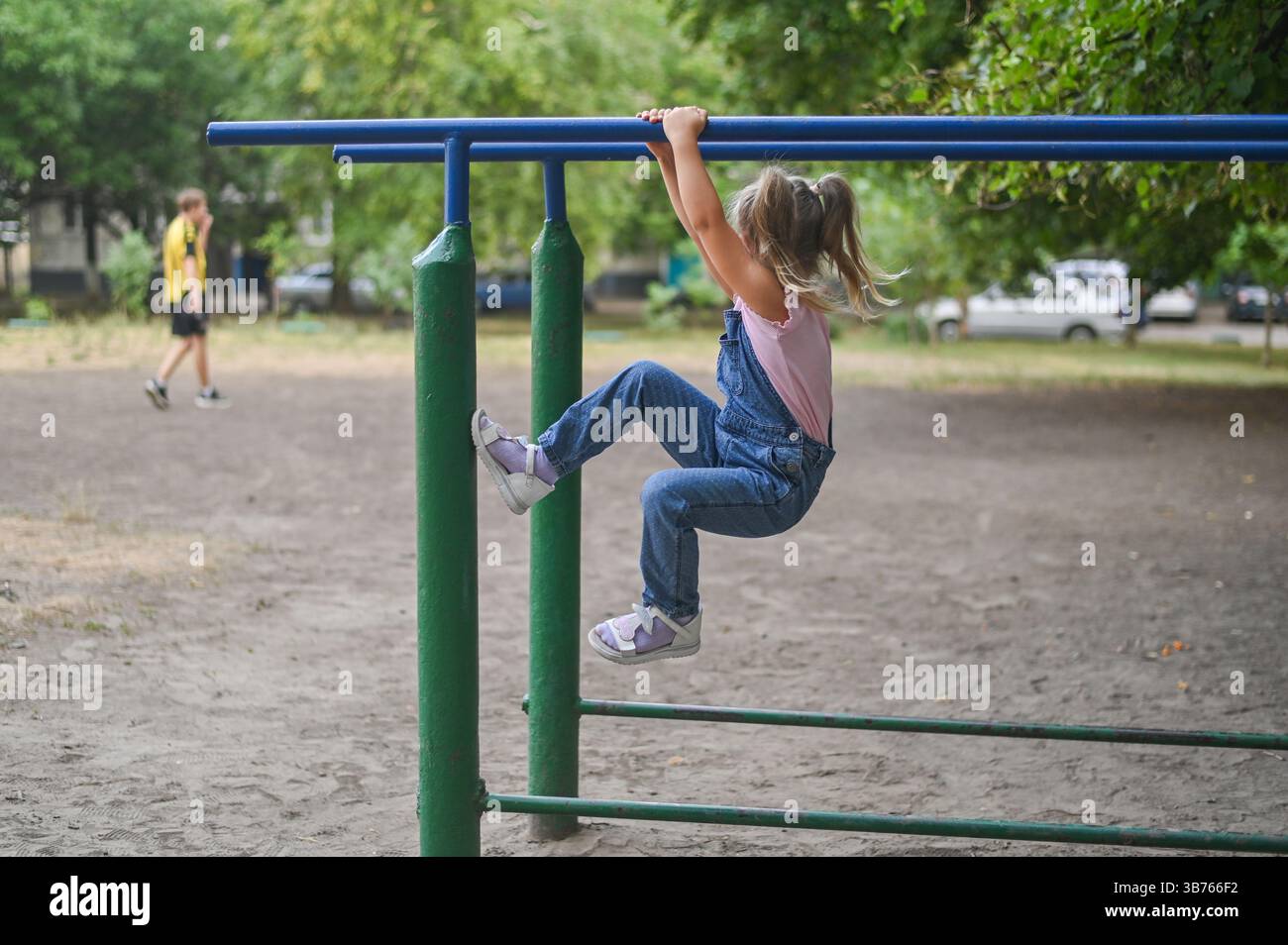 the girl is trying to climb on the crossbar Stock Photo - Alamy