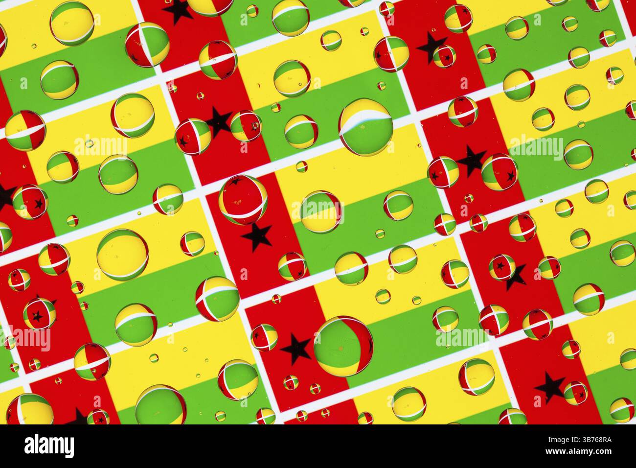 Flags of Guinea-Bissau, behind a glass covered with rain drops.Pattern from Guinea-Bissau flags ...