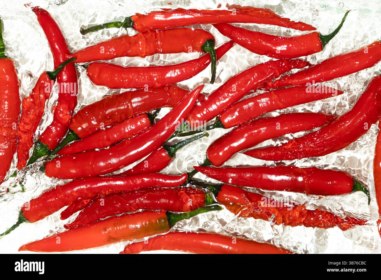 Floating Chili Peppers in Transparent Still Water Stock Photo - Alamy