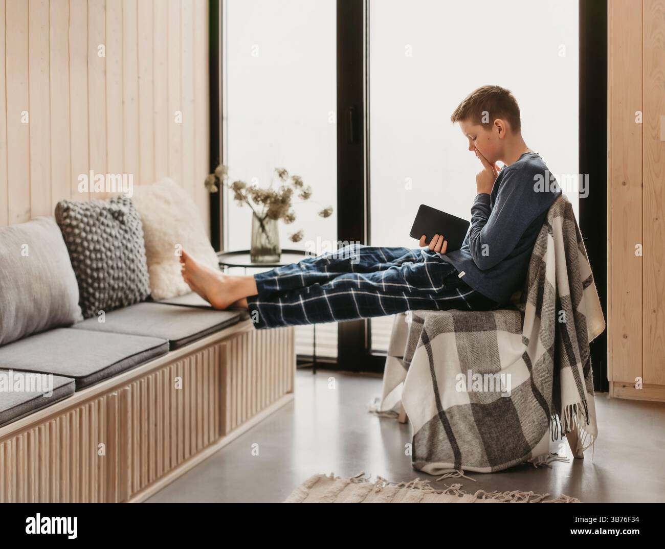 Teen Boy Reading Book in Cozy Log Cabin Stock Photo - Alamy