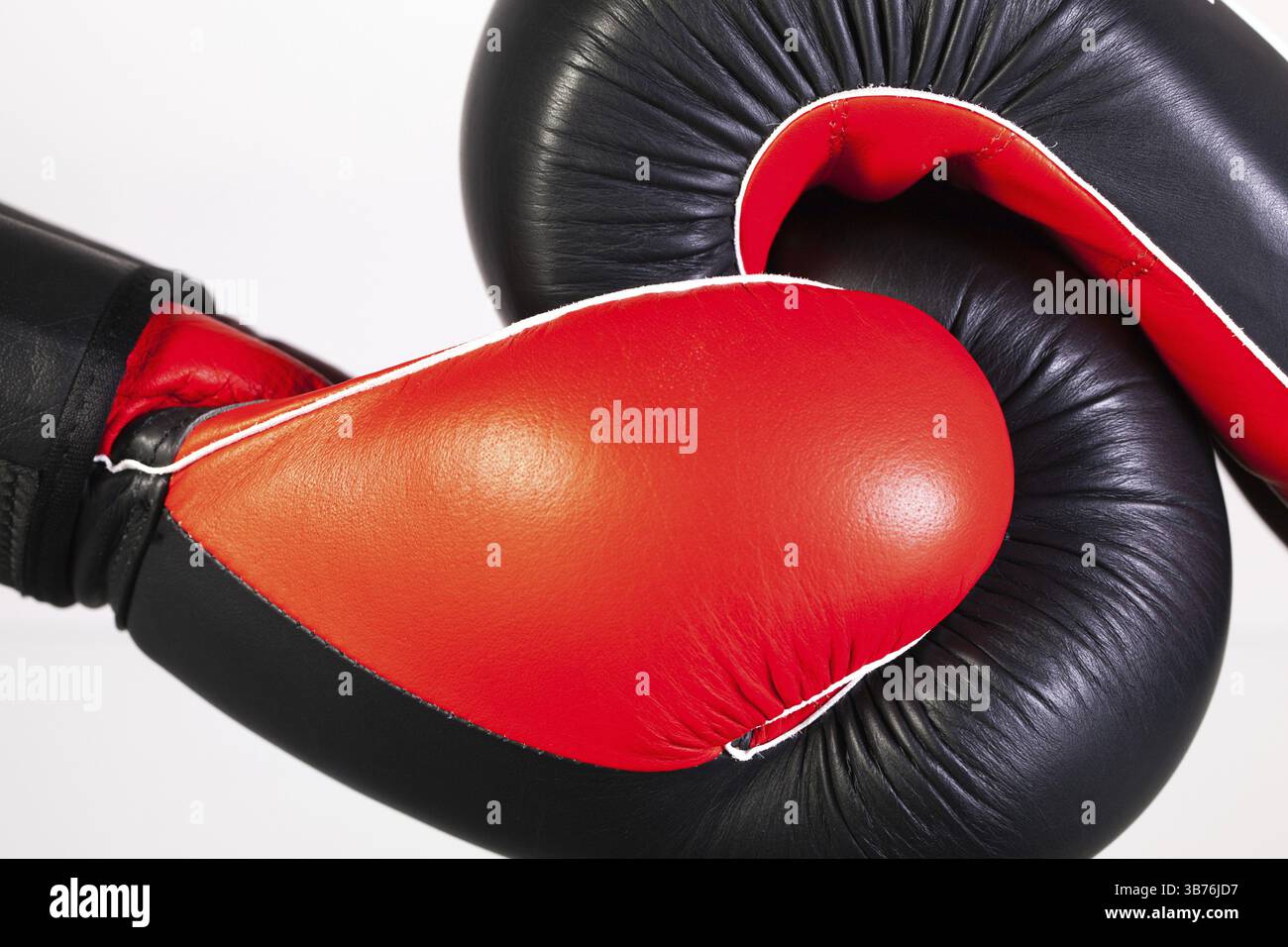 Red and black boxing gloves on a glass table isolated on white ...