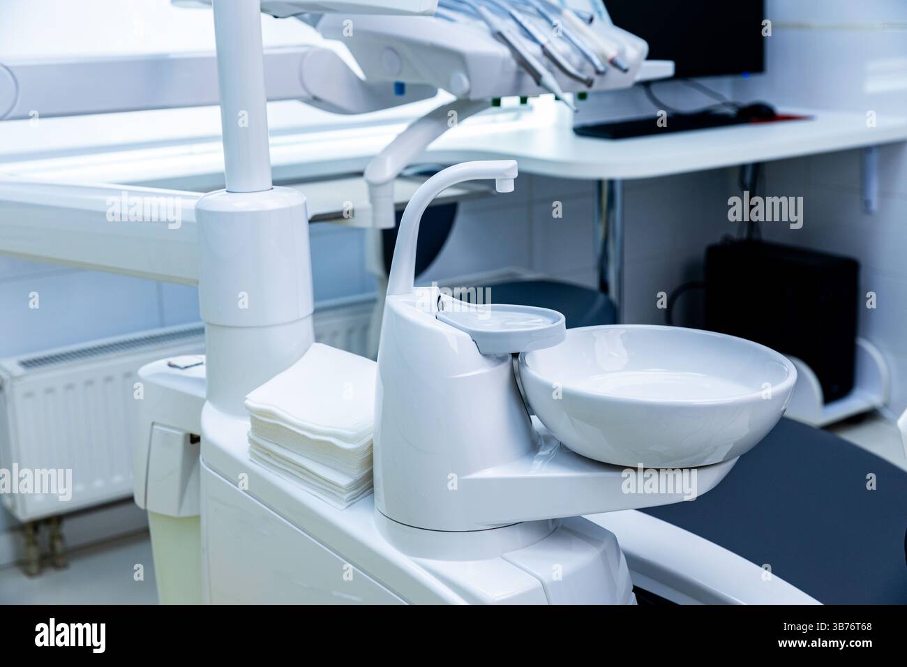The image features a well-equipped dental clinic with a modern white ...