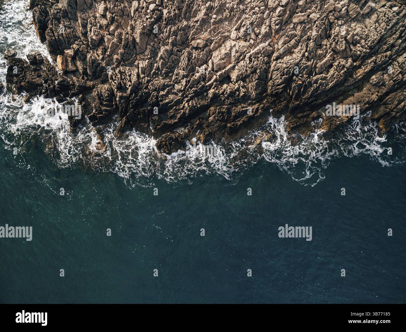Top view of the blue sea with waves beating on beach and rocks Stock ...