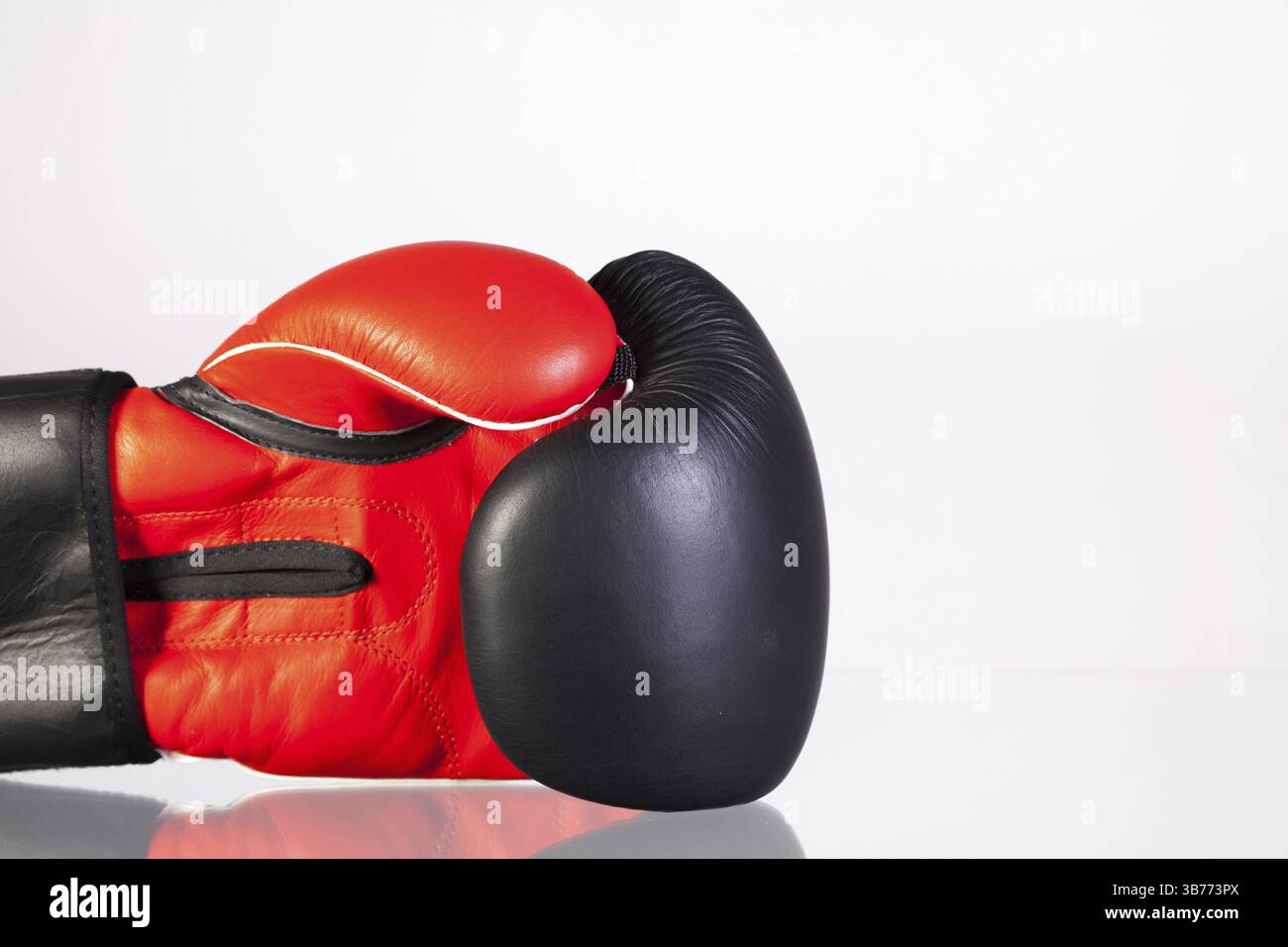 Red and black boxing gloves on a glass table isolated on white ...