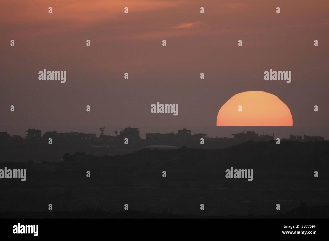 The sun sets behind the northern Gaza Strip as seen from southern ...