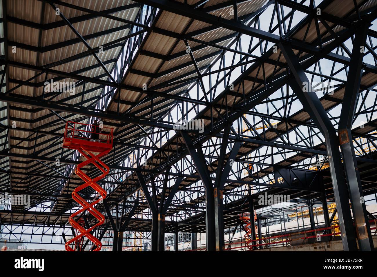 Steel structure of industrial building and scissor lift Stock Photo - Alamy