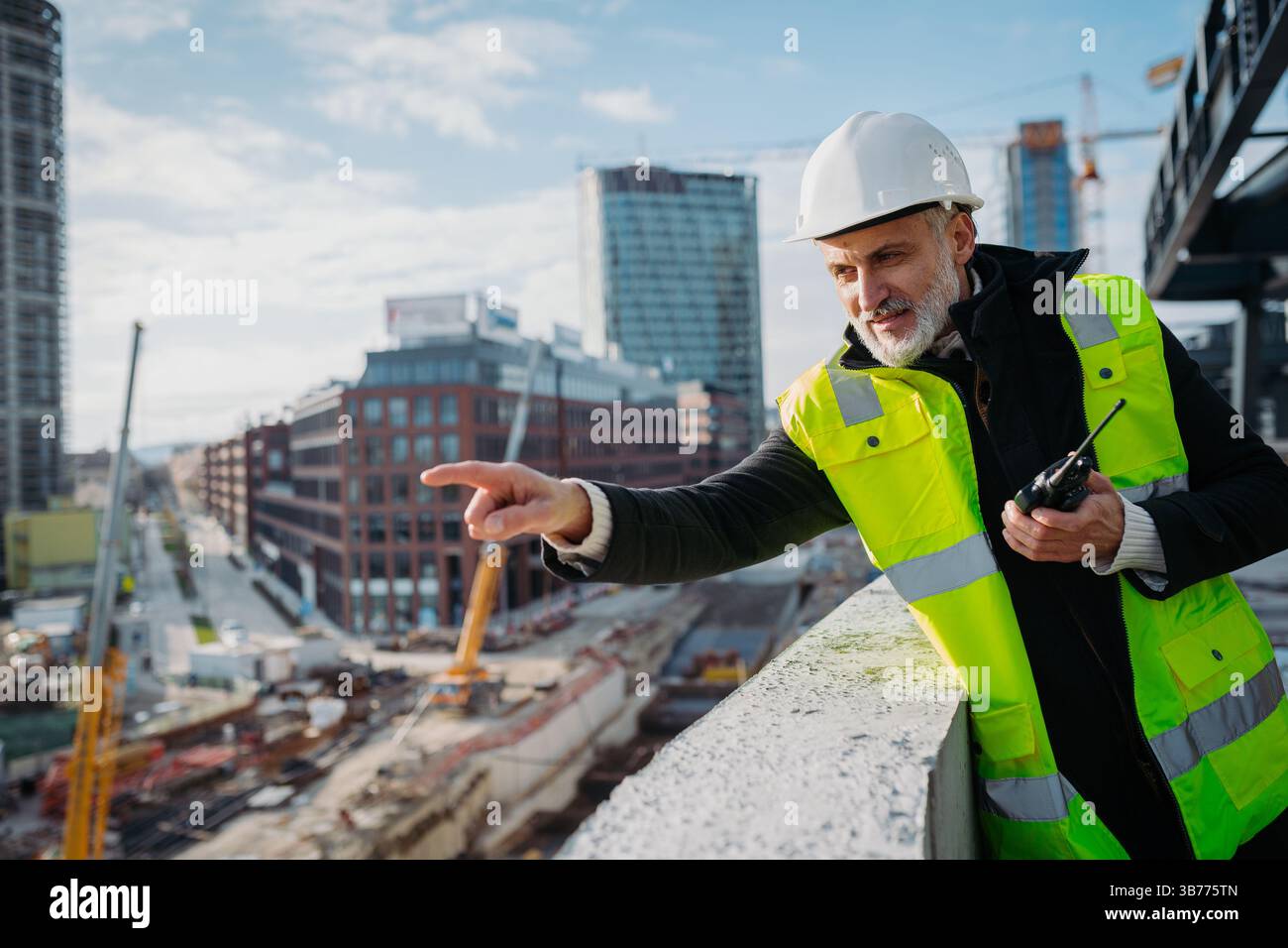 Site manager giving instructions over radio during building inspection ...