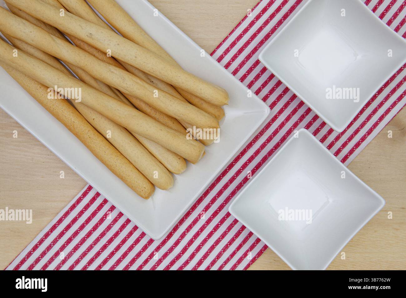 Typical Italian breadsticks with salt and olive oil on the wooden table ...