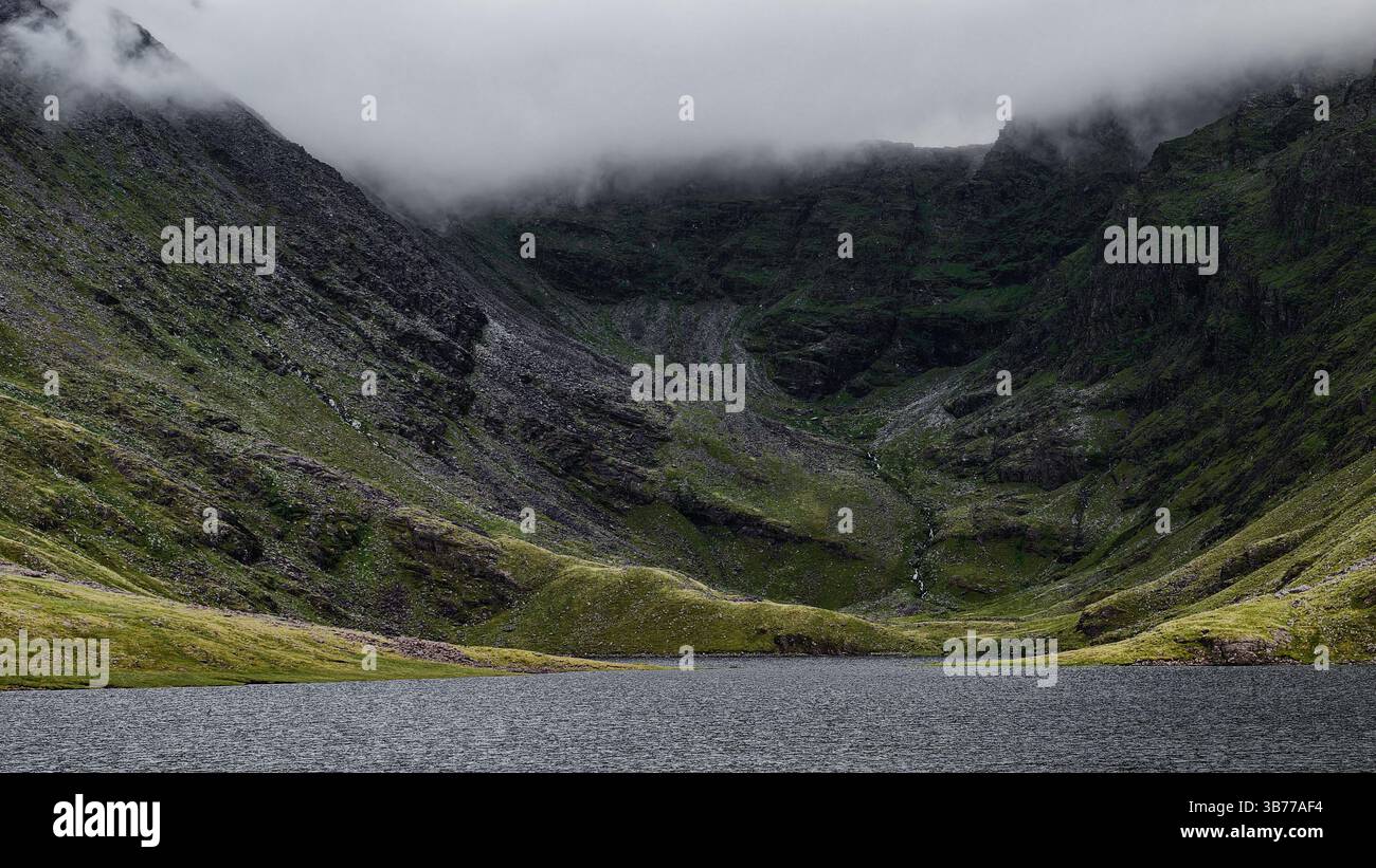 Coomloughra Lough lies serenely at the base of steep, green-clad ...