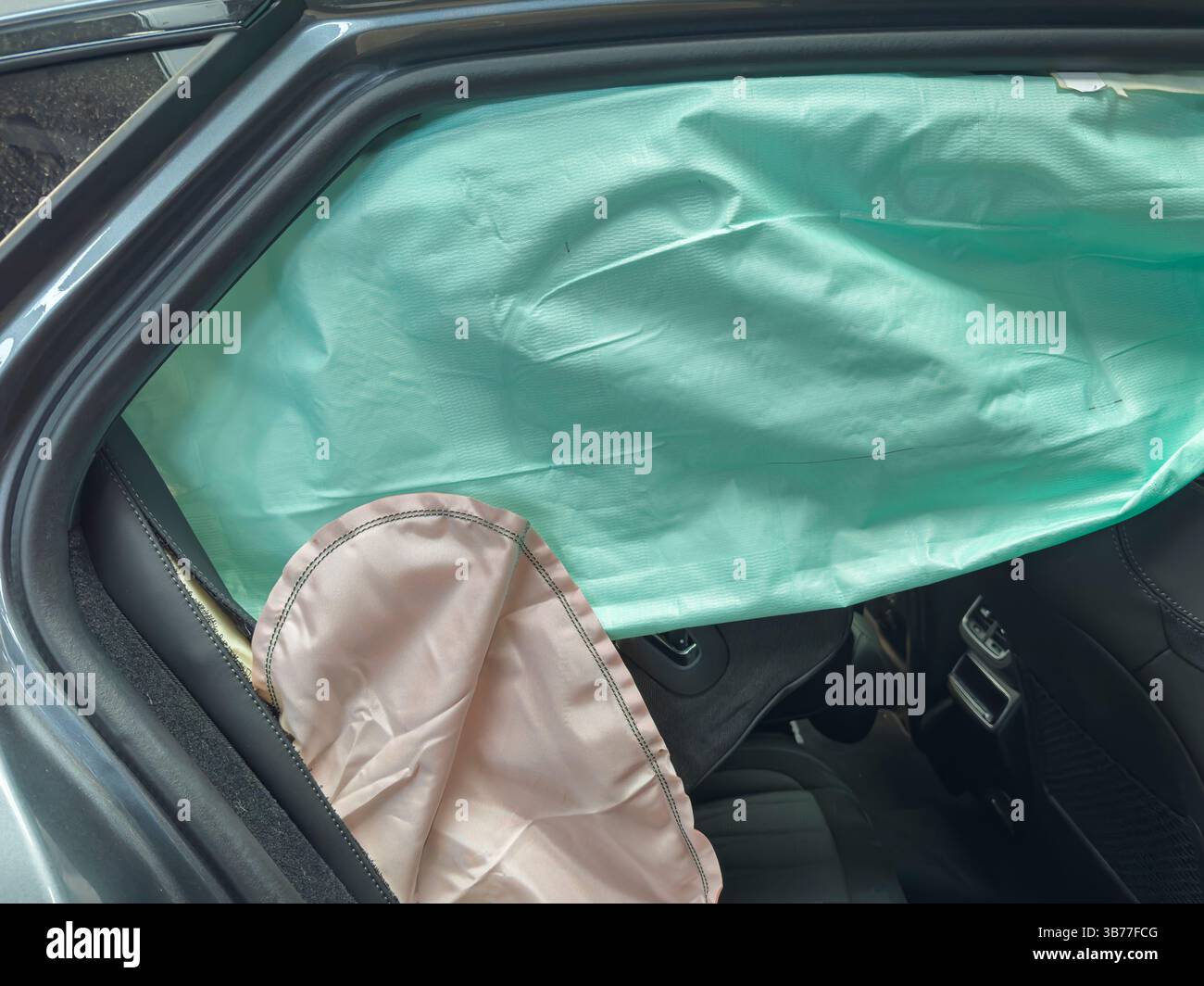 A car interior showing deployed airbags after a collision, highlighting ...