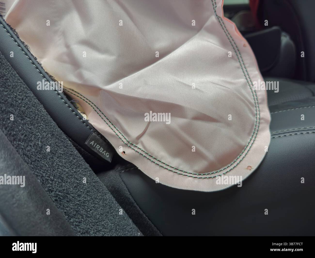 Deployed airbags on a car seat with visible stitching and fabric after ...
