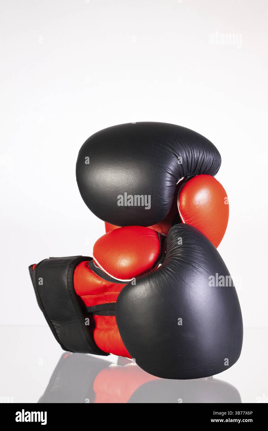 Red and black boxing gloves on a glass table isolated on white ...