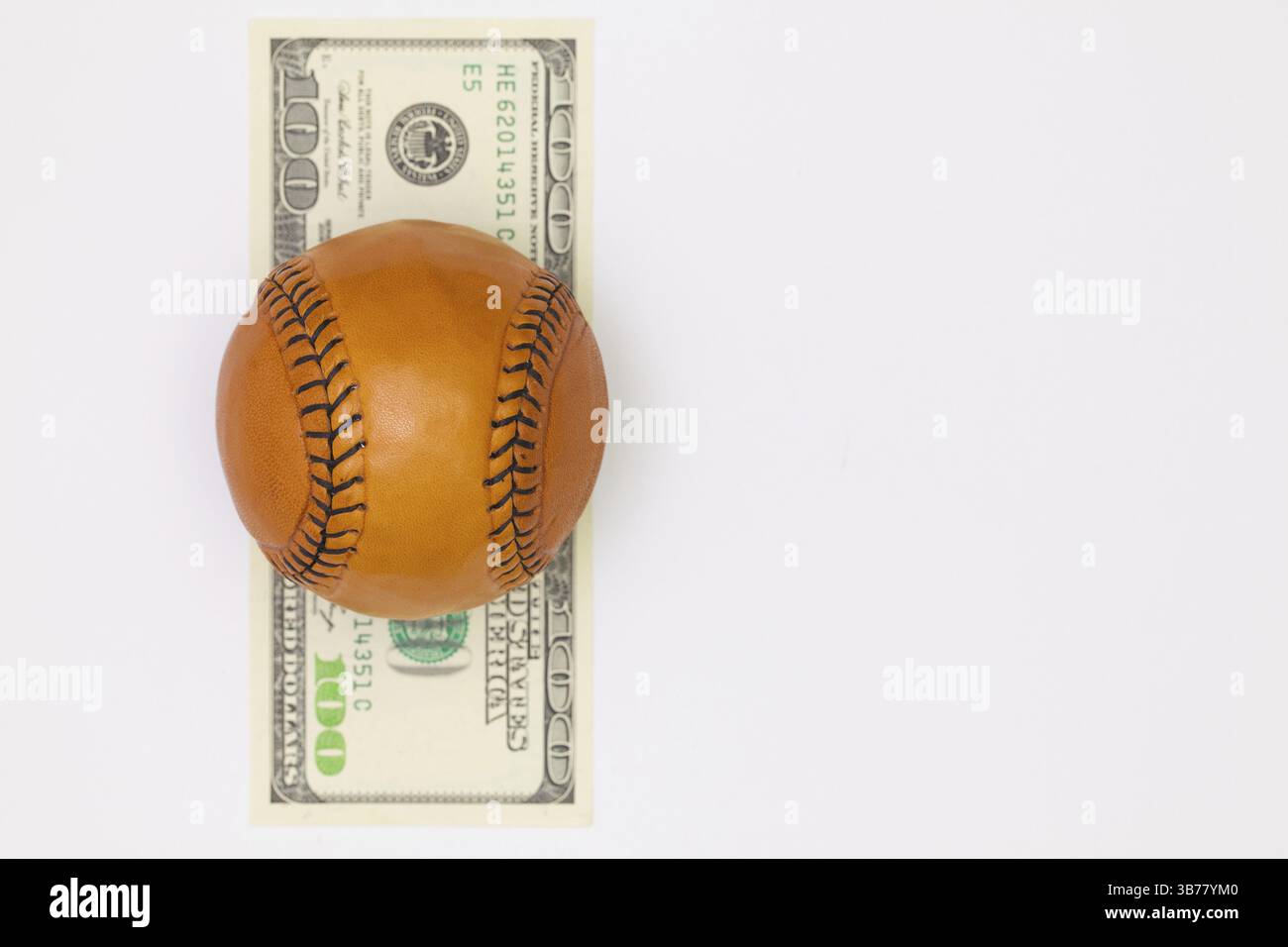 Leather baseball ball and us dollar banknotes on the white table. Flat ...