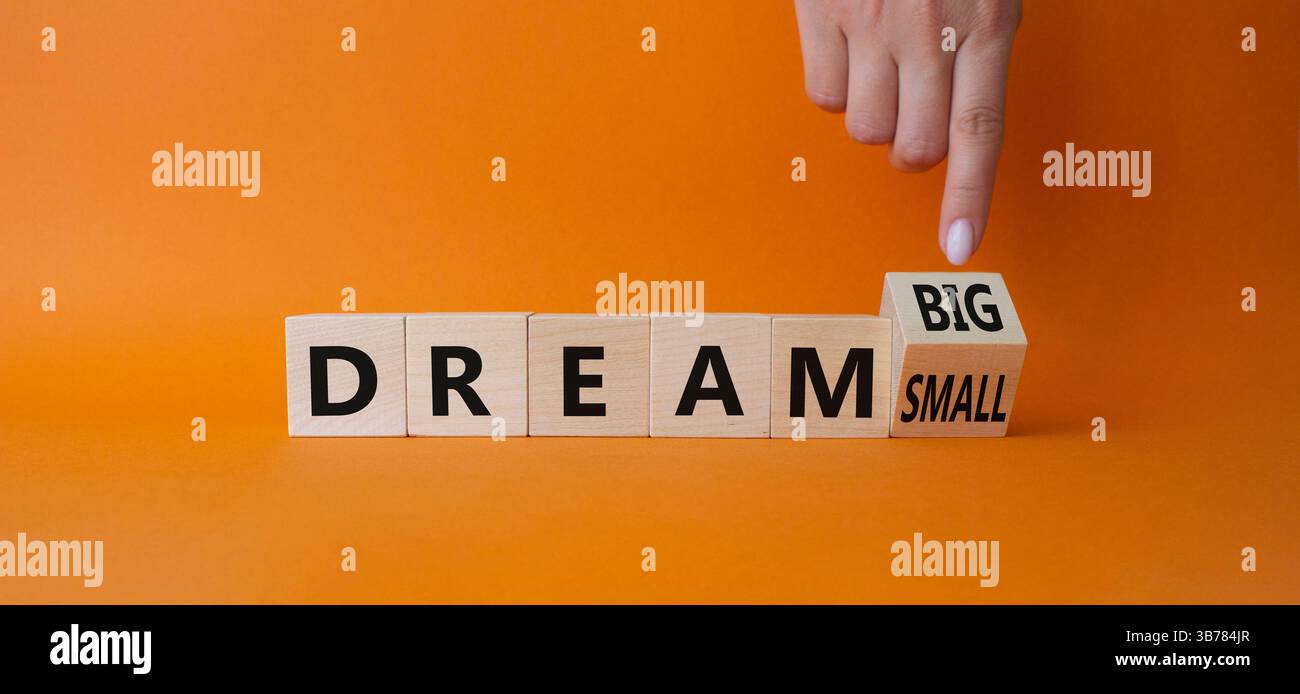 Dream Big vs Small symbol. Businessman Hand points at wooden cubes with ...