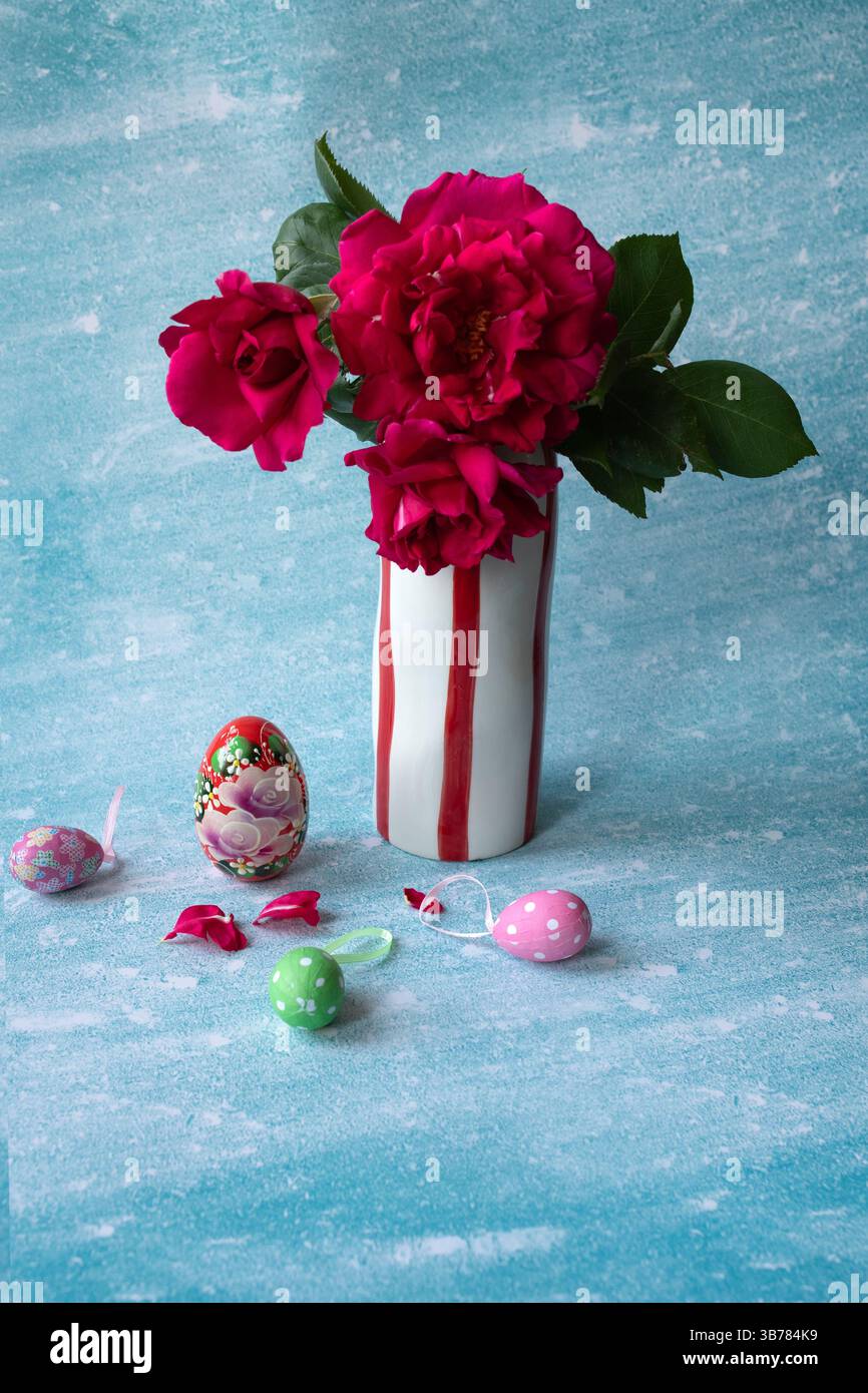 Easter and spring background with Easter eggs, vase and red roses on ...