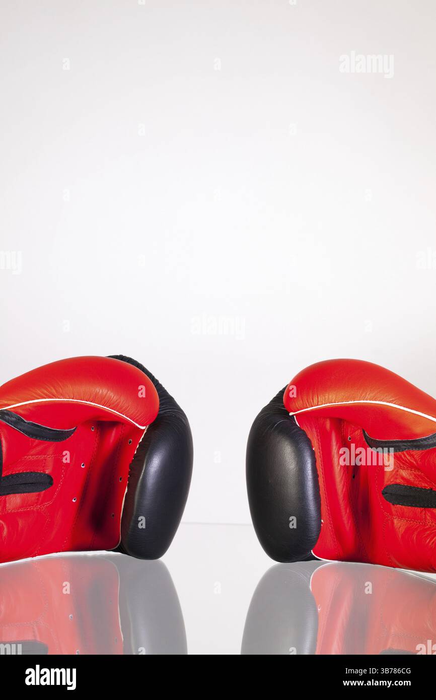 Red and black boxing gloves on a glass table isolated on white ...