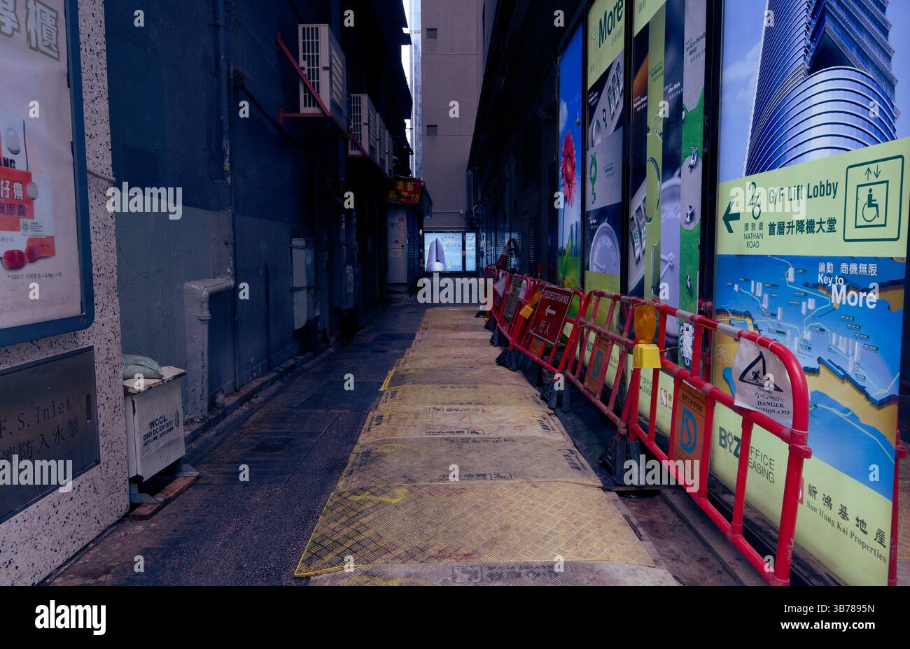 Corrugated mats and warning signs carve a narrow path through a ...