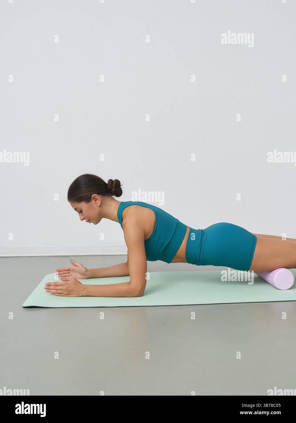 Using a yoga foam roller for upper body relaxation during a fitness ...