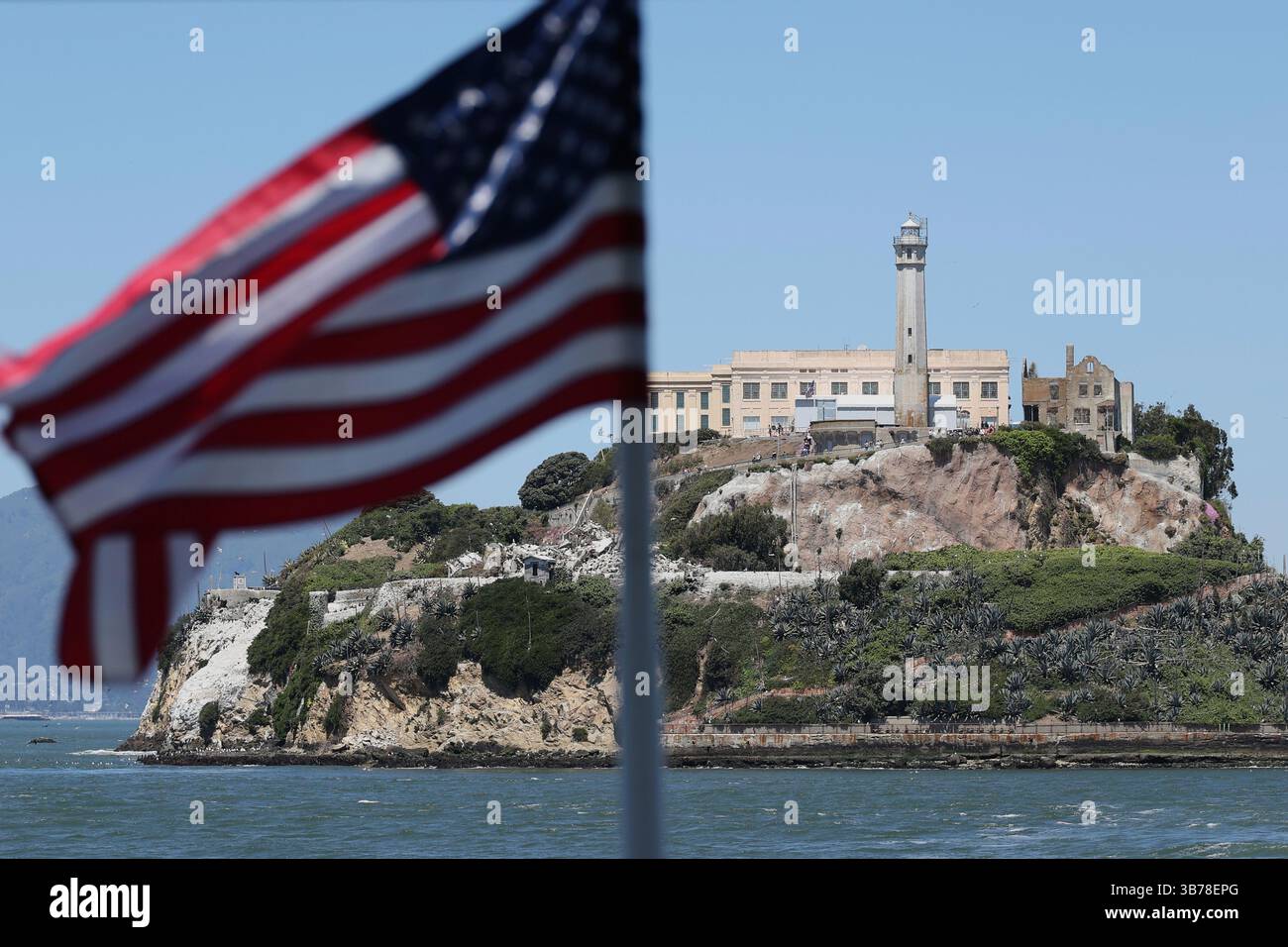 An American flag flies on the back of a ferry in front of Alcatraz ...