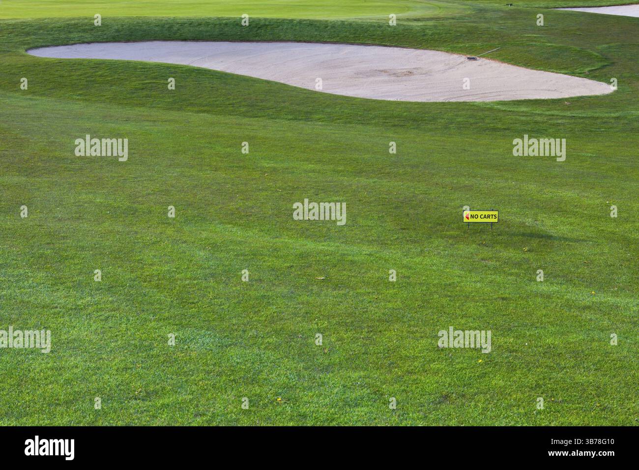The golf bunker and a directional sign for golf carts Stock Photo - Alamy