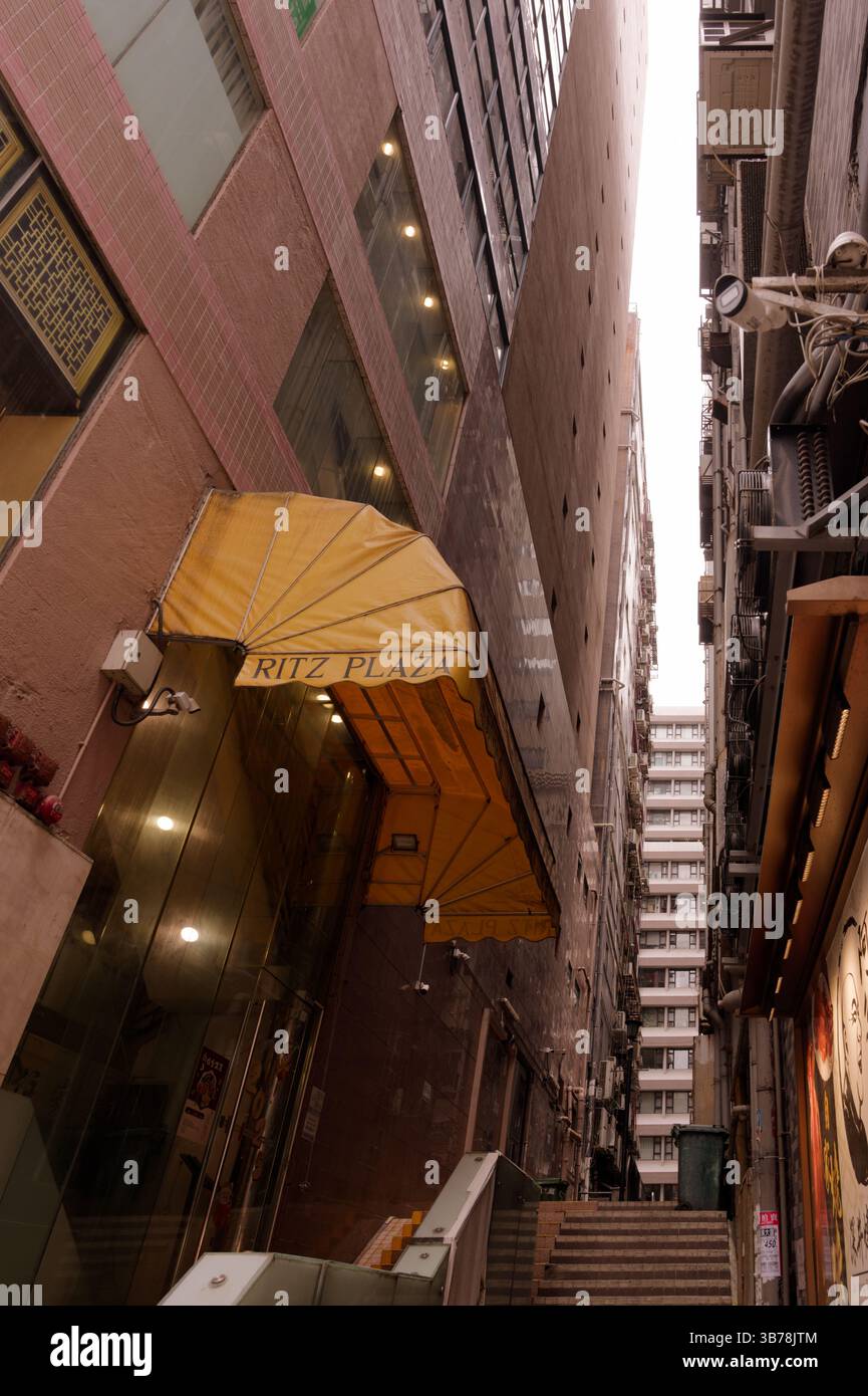 A golden awning marked "Ritz Plaza" stretches over a narrow downtown ...