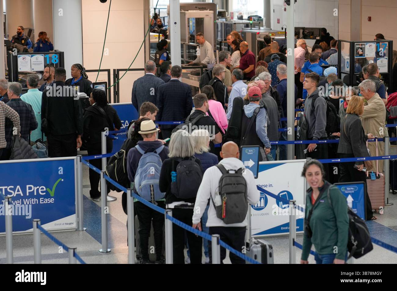 Travelers make their way through security at Newark Liberty ...