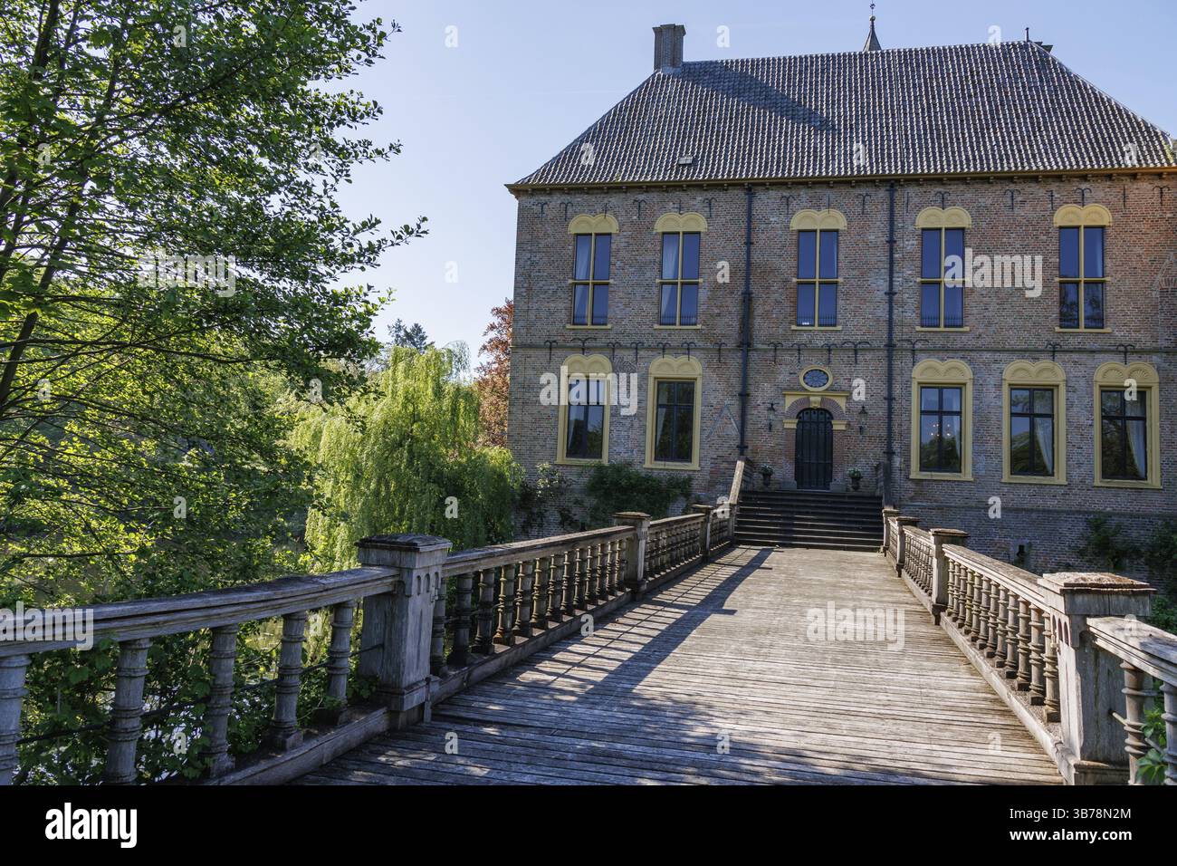 A historic wooden bridge leads directly to the entrance of a stately ...