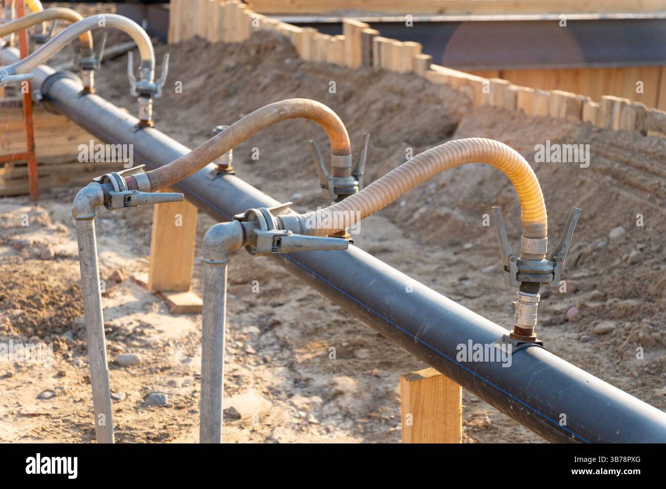 A close-up view of a series of flexible hoses connected to a pipe at a ...