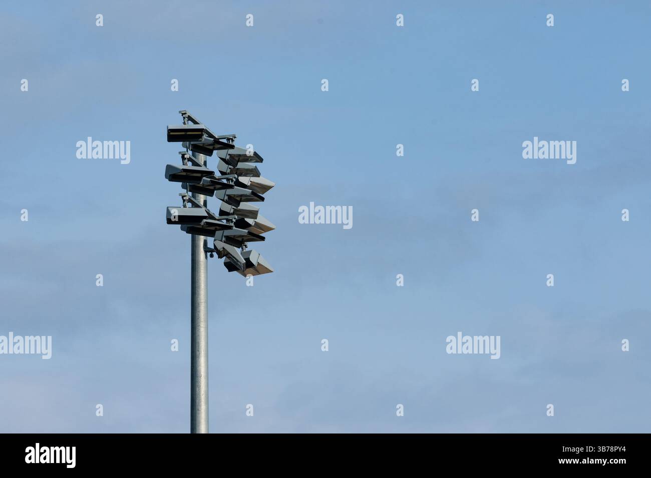 Tall floodlights extend upward from a pole, illuminating the area below ...