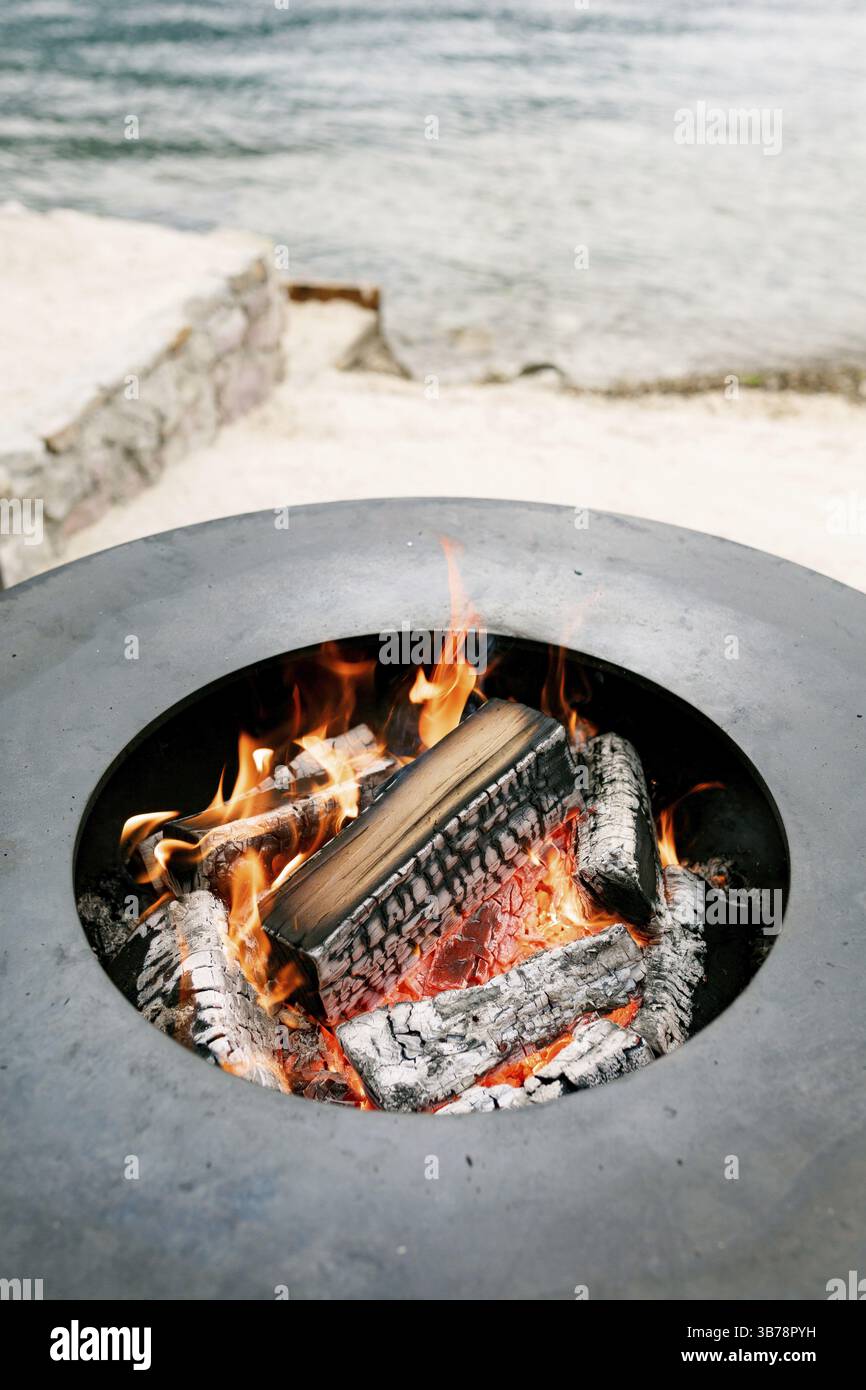 A close-up of the round frying surface with burning wood inside Stock ...