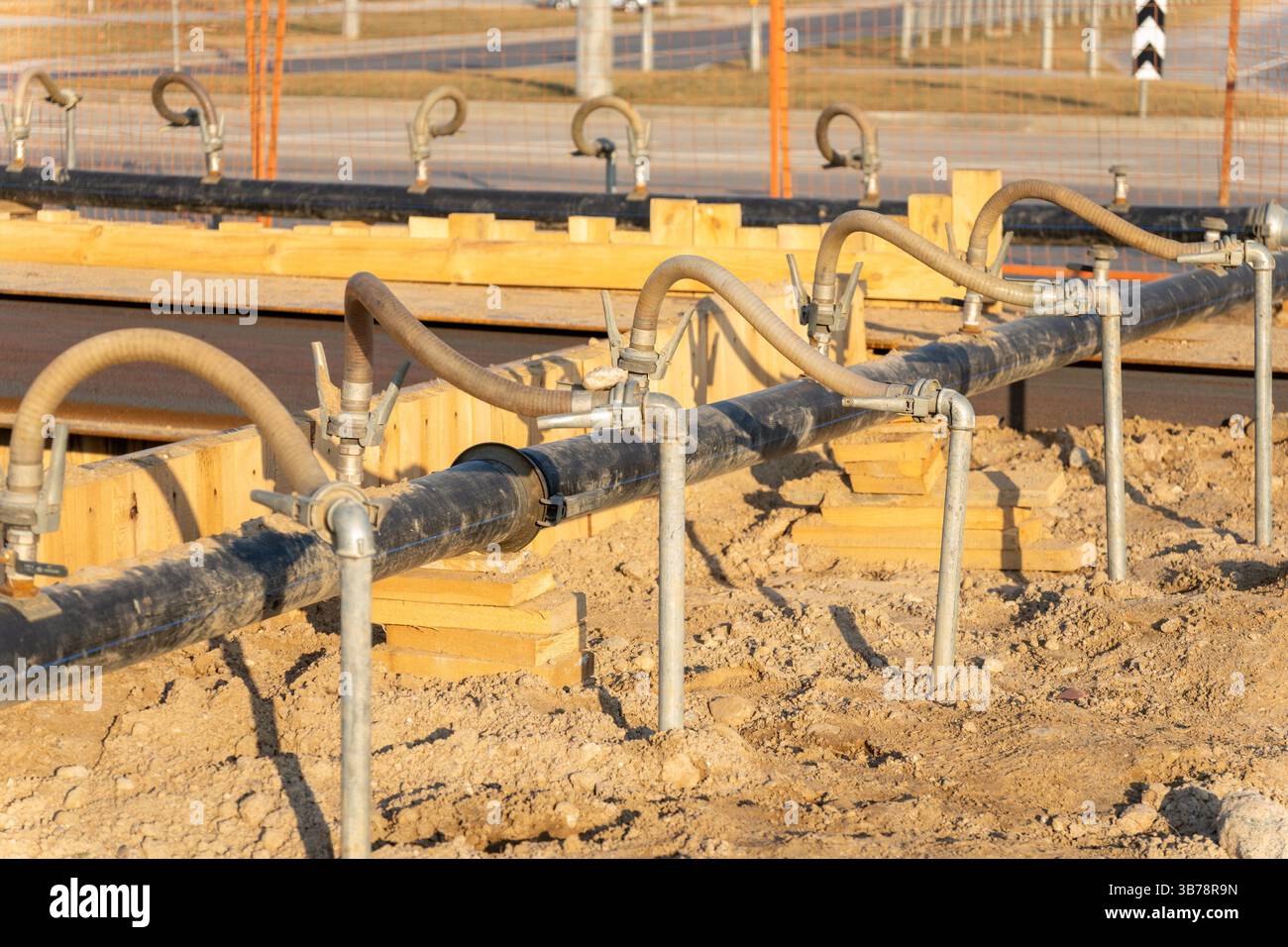 A close-up view of a series of flexible hoses connected to a pipe at a ...