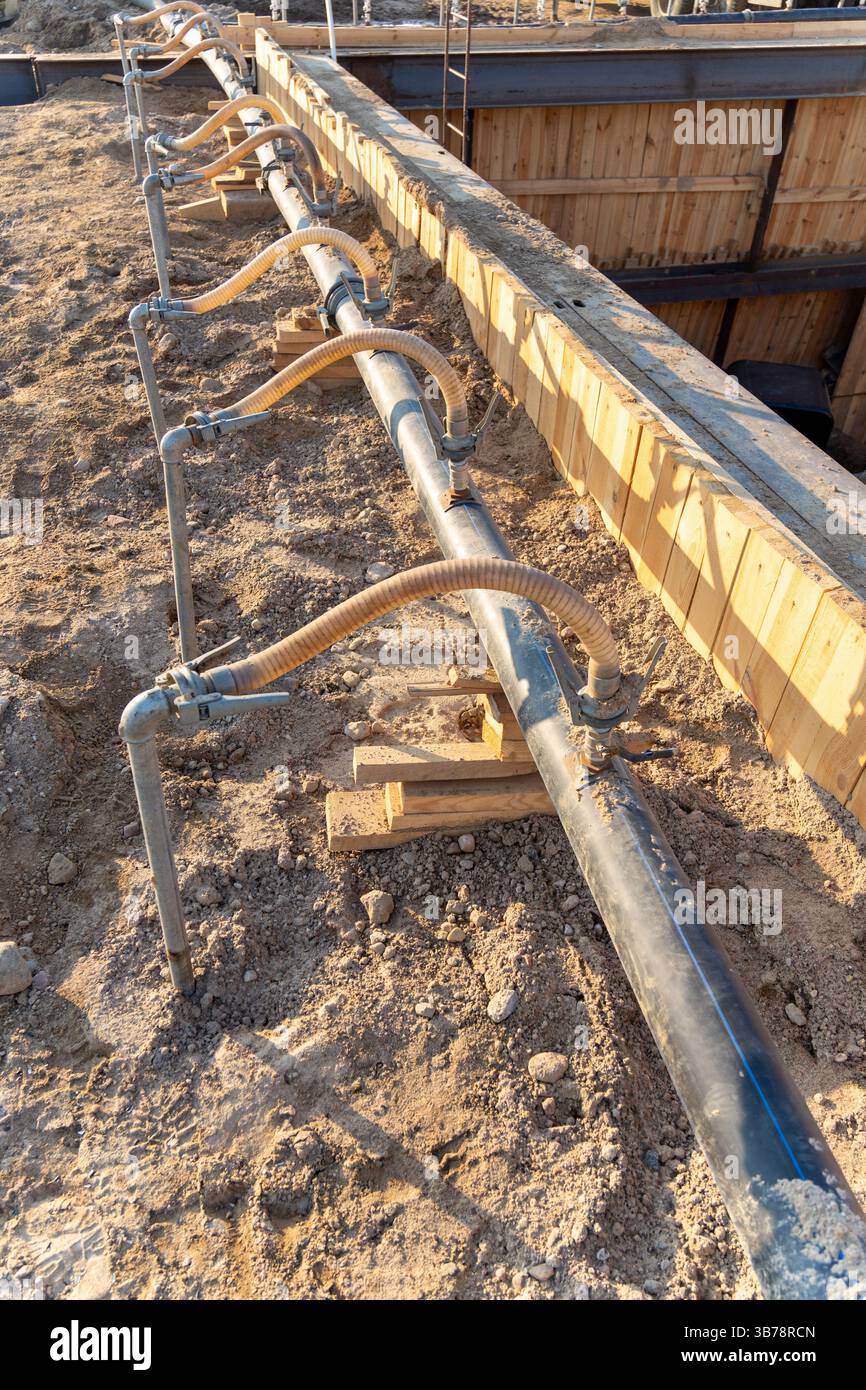 A close-up view of a series of flexible hoses connected to a pipe at a ...