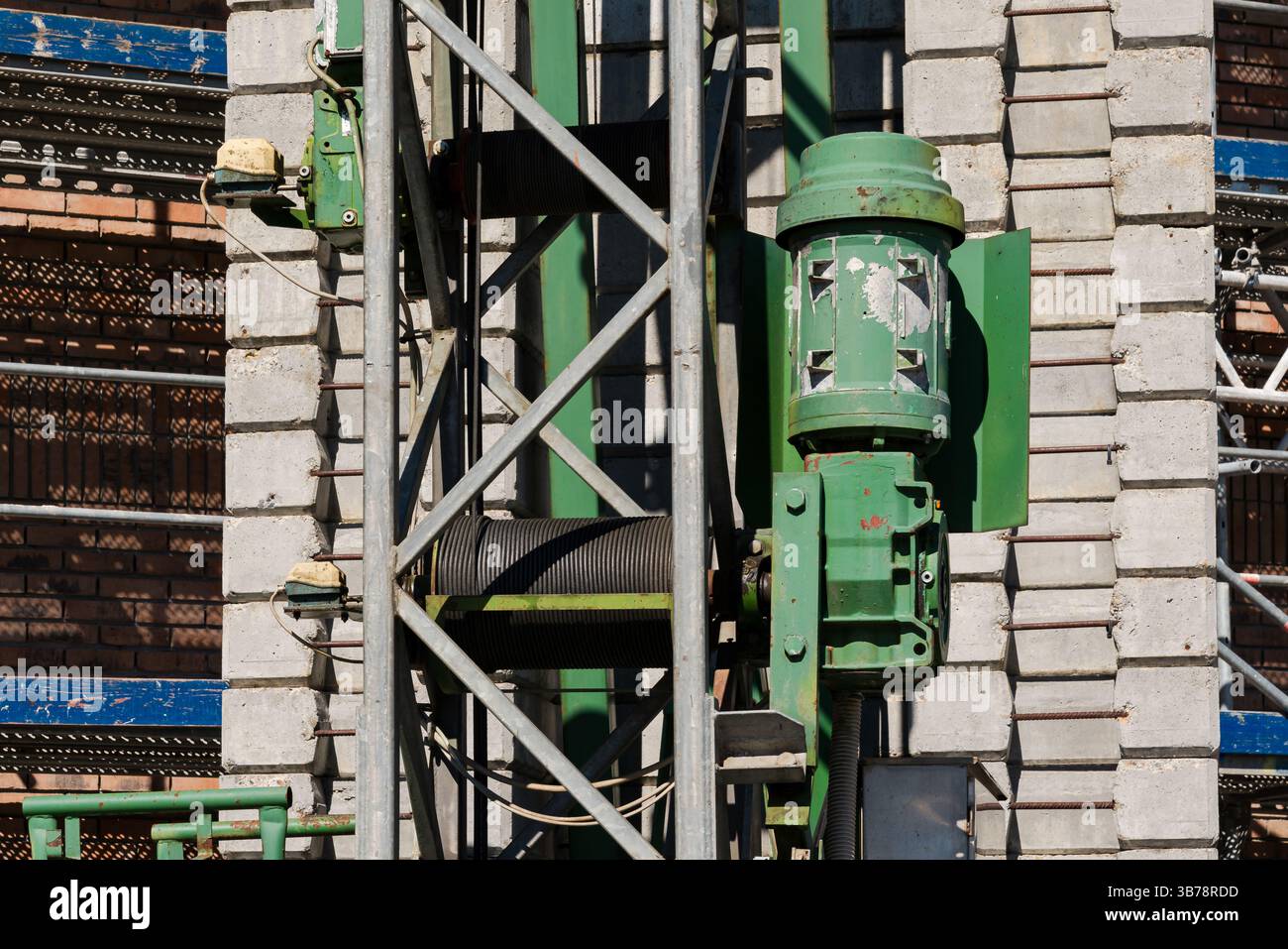 Heavy machinery is visible on a construction site, featuring a green ...
