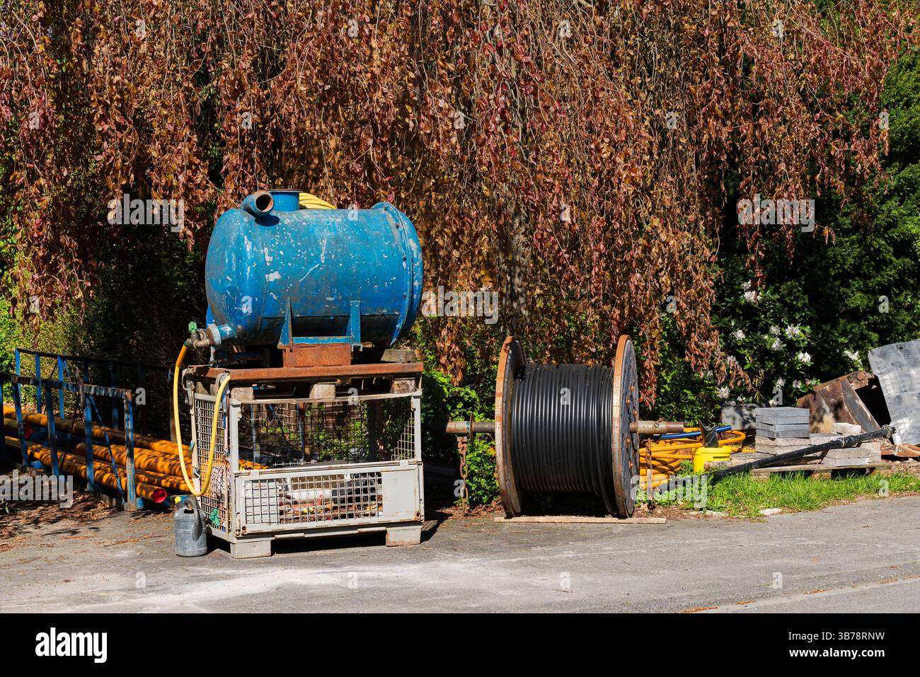 Machinery and materials are gathered in an outdoor area during daylight ...