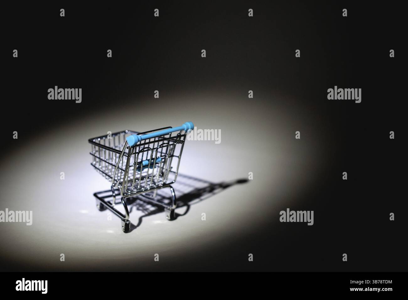 Spotlight and shopping trolley in the dark room. Spotlight effect for ...