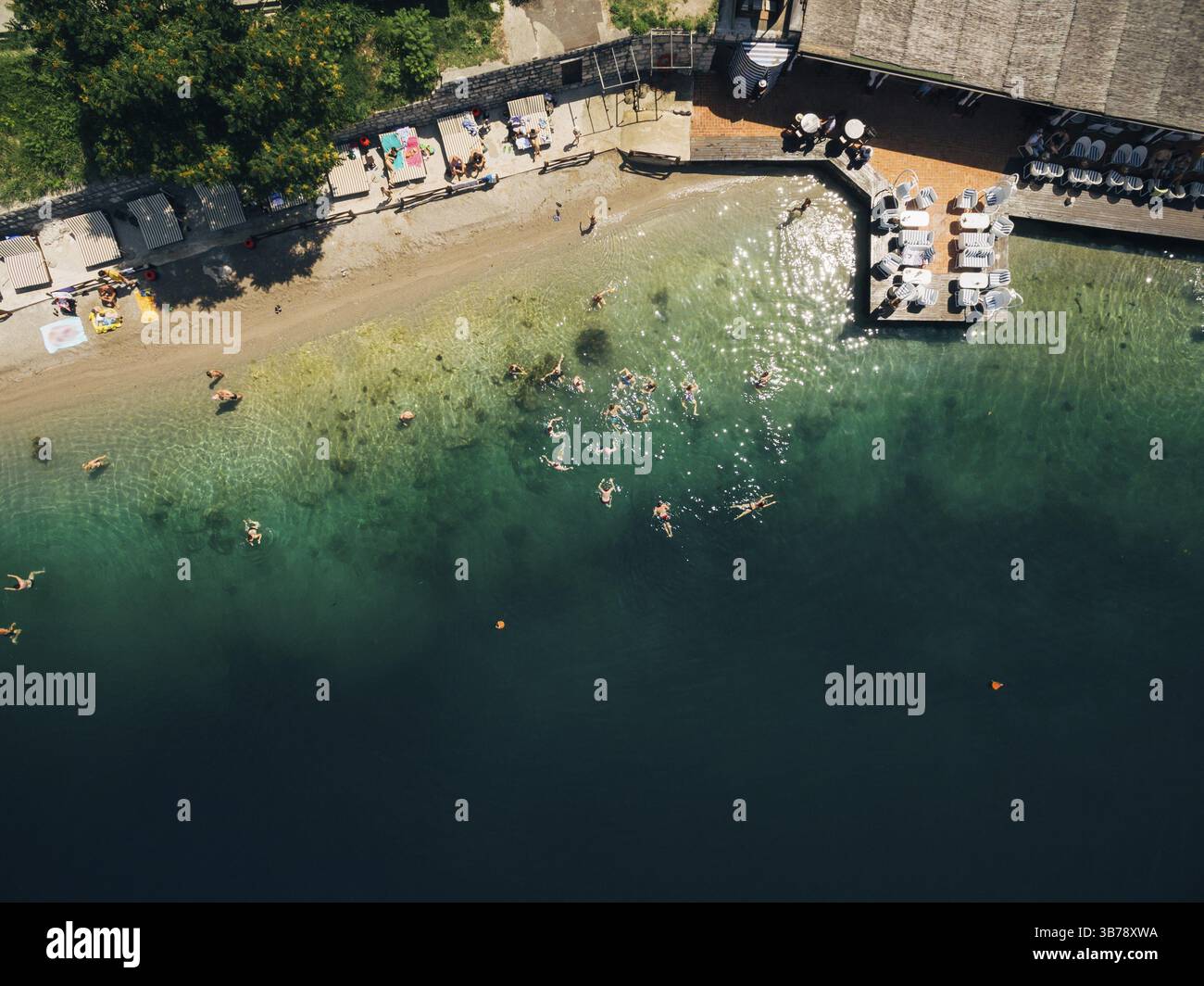 Aerial view of people swimming in the sea. Beach cafe by the sea ...