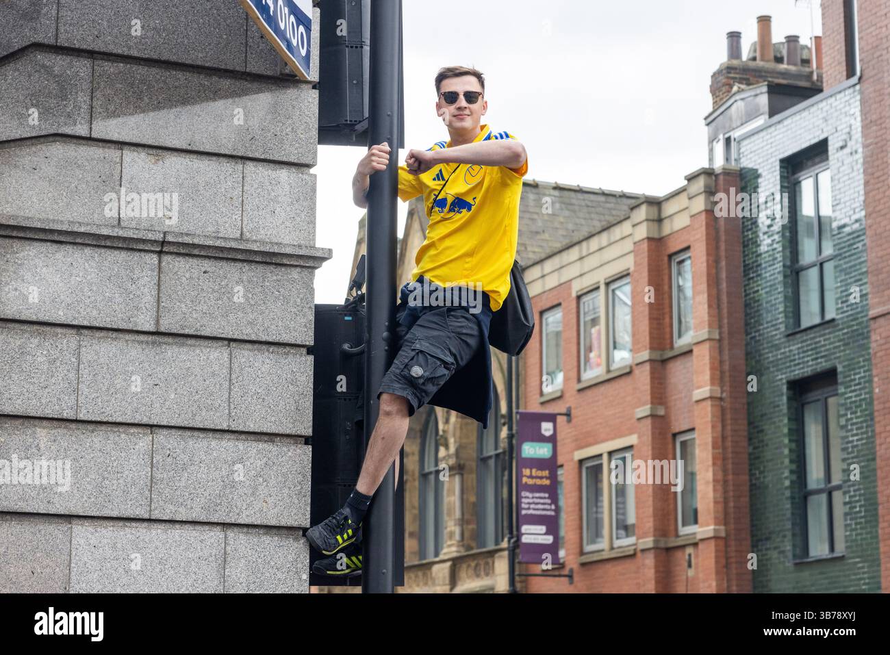 Leeds, UK. 05 MAY, 2025. Fan climbs traffic light as Leeds United staff ...