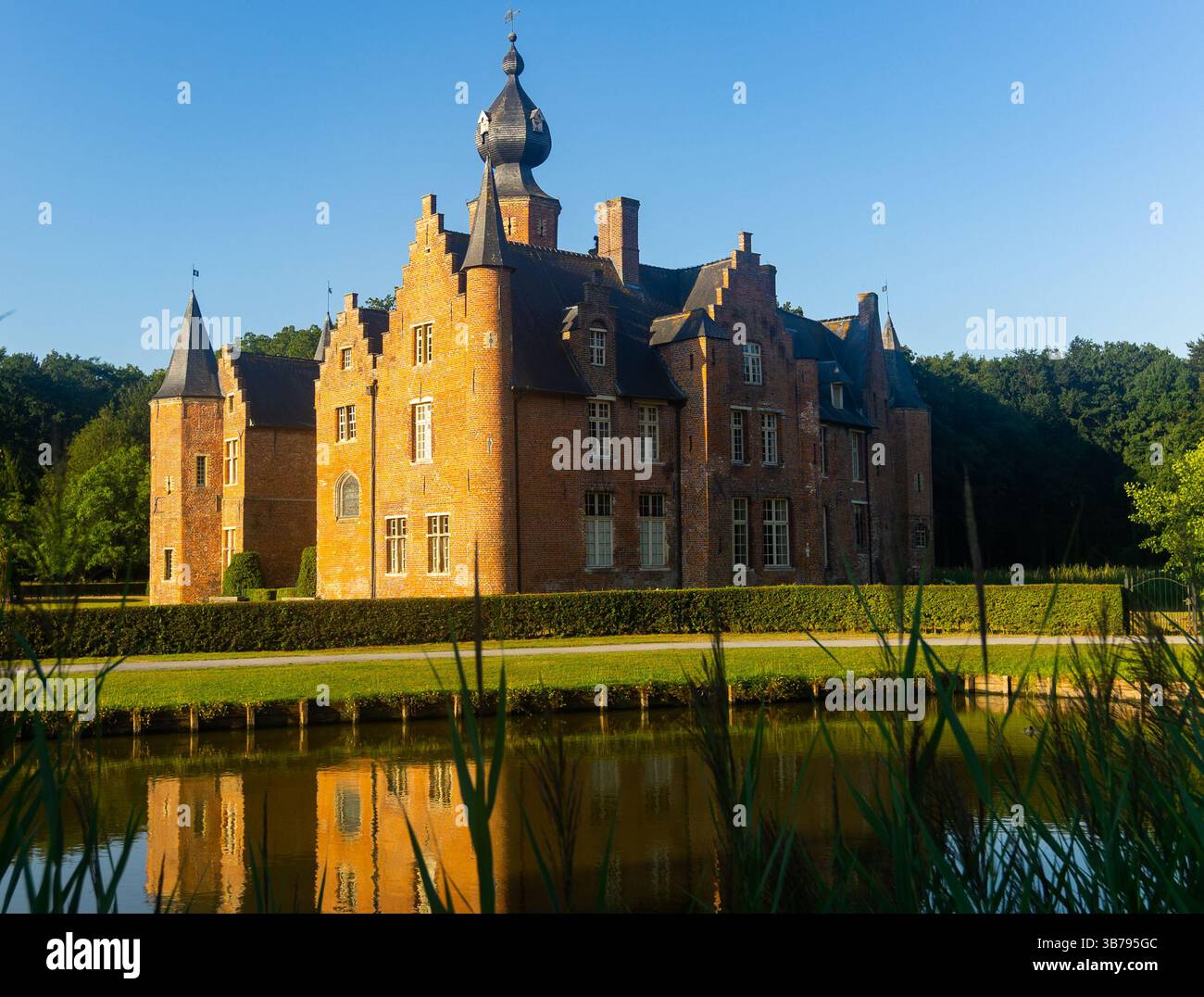 Medieval castle in Flemish town of Rumbeke reflecting in water of pond ...