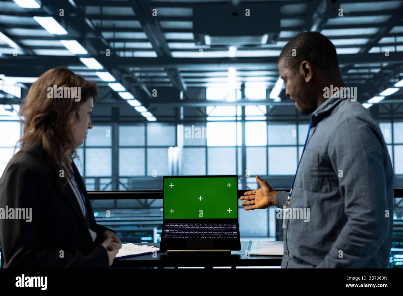Engineers in data center using green screen mockup laptop to develop disaster recovery plans. IT ...