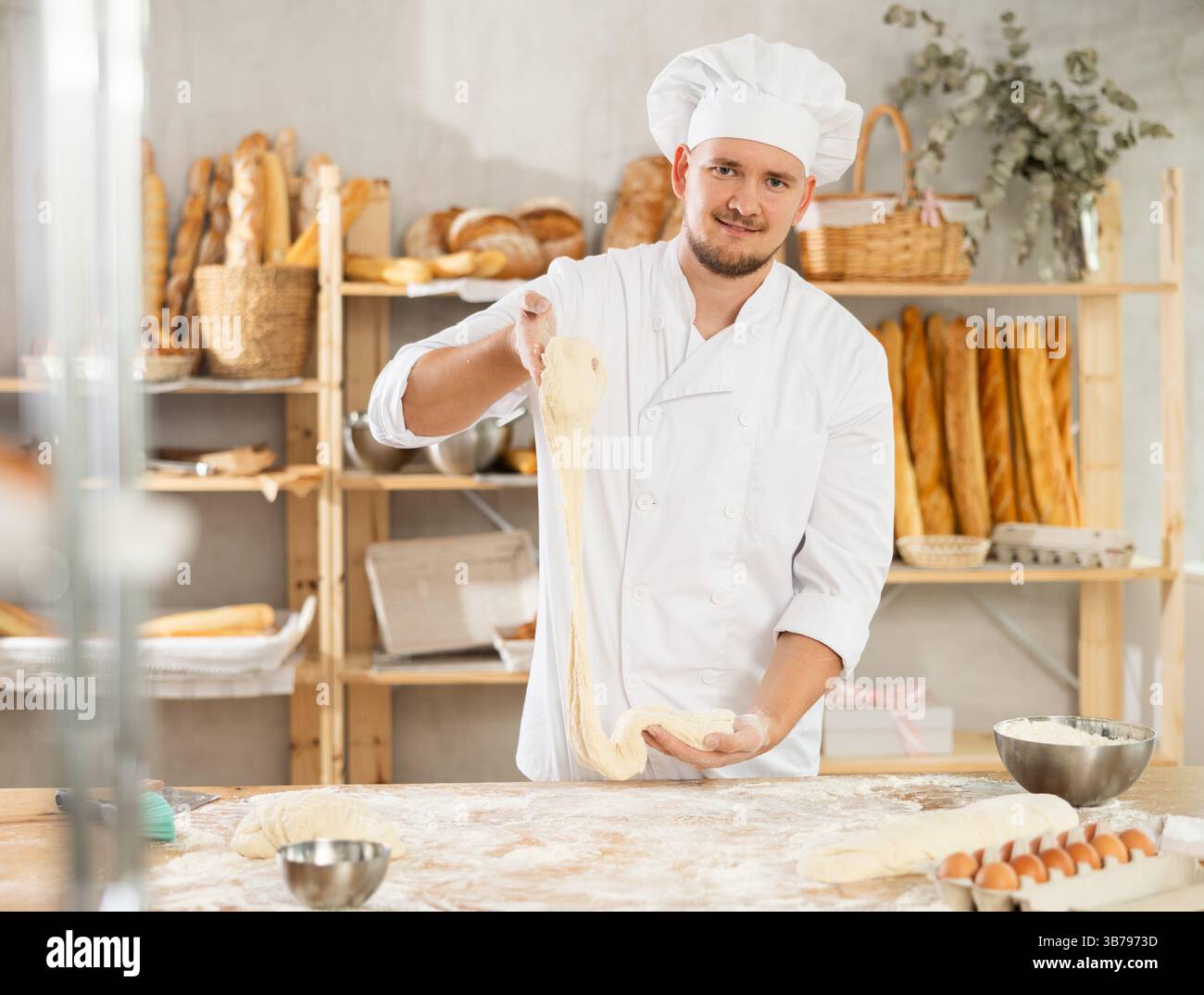 Process of making baguette, loaf or bread in bakery - baker kneads and ...