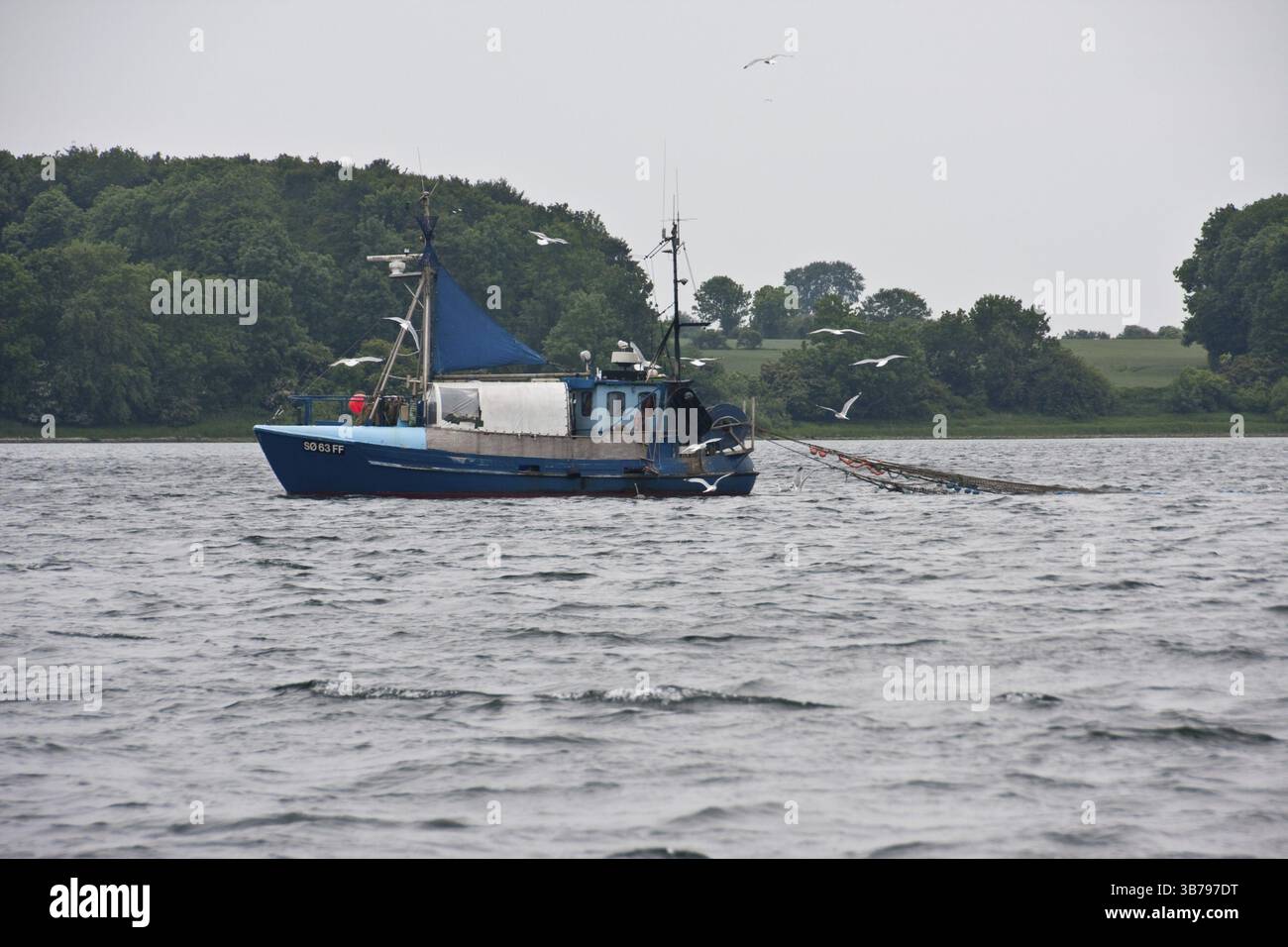 Fishing boat with trawl net Stock Photo - Alamy