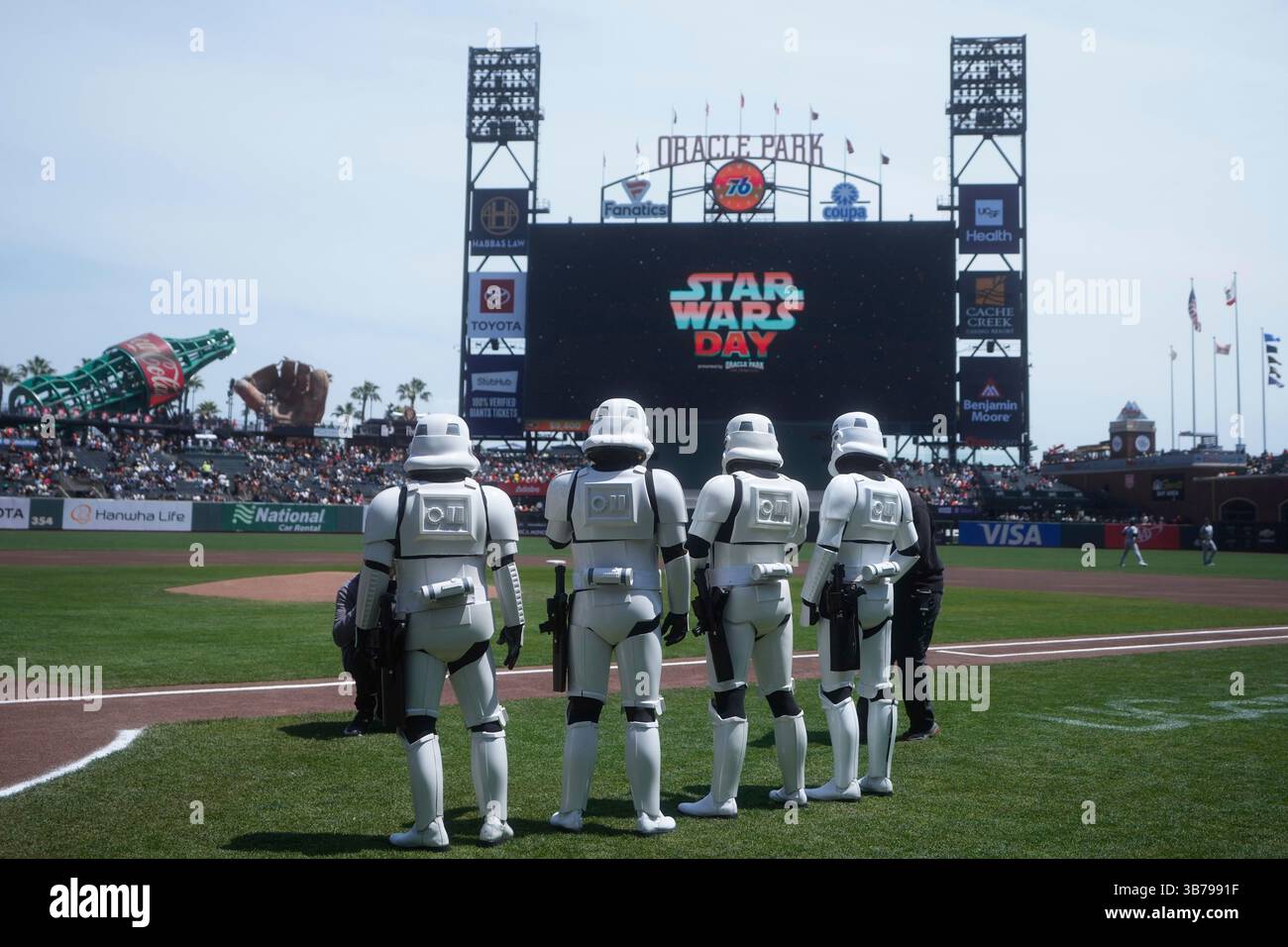 People dressed as Star Wars stormtrooper characters stand on the field ...