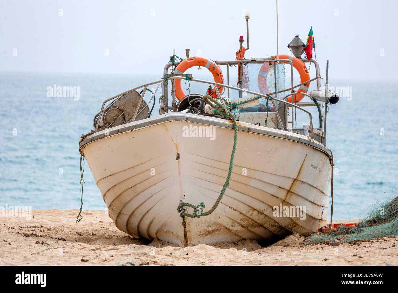 Traditional Portuguese fishing boat anchored on the beach in the ...