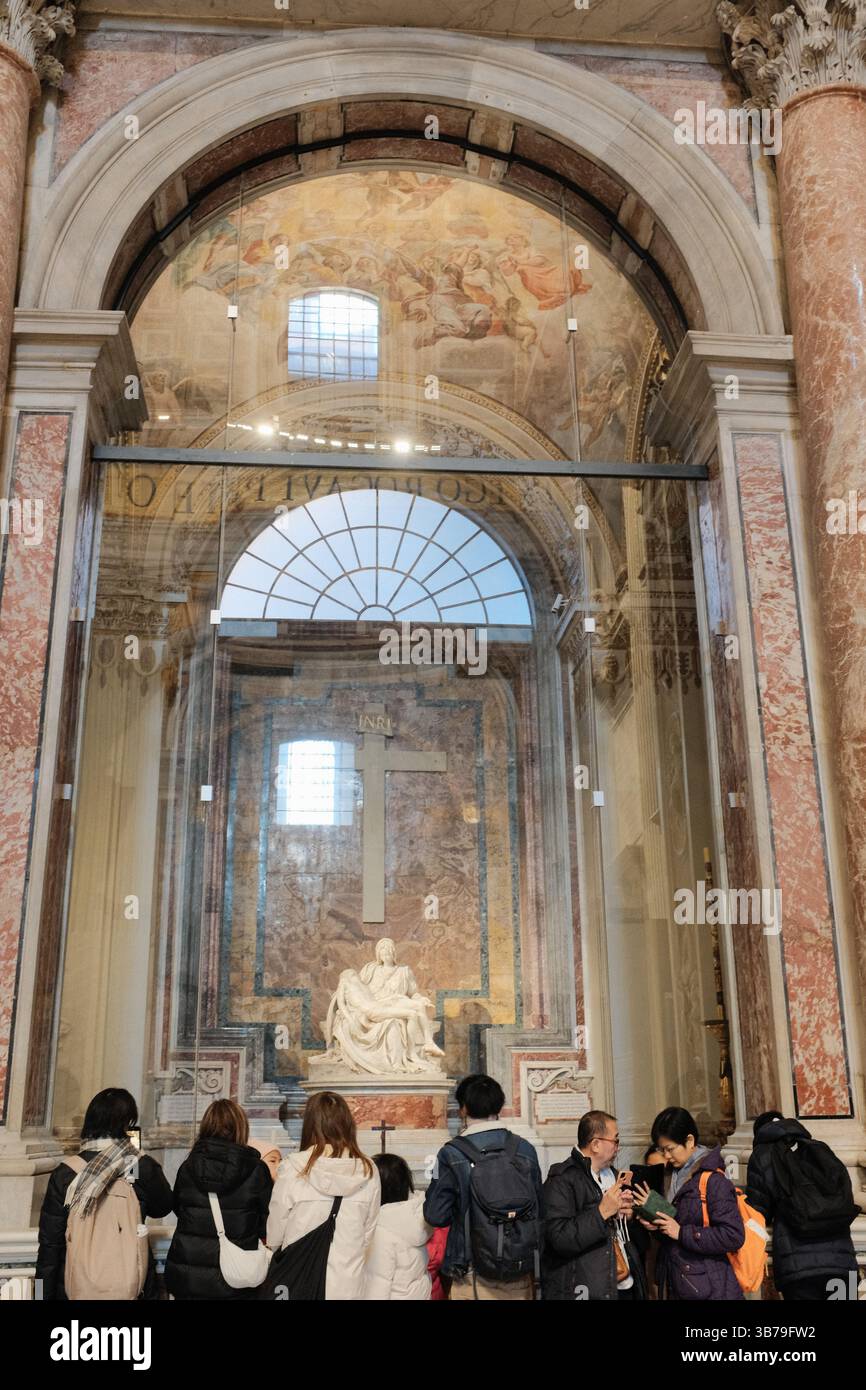 Tourists admiring Michelangelos Pieta sculpture behind glass in Saint ...