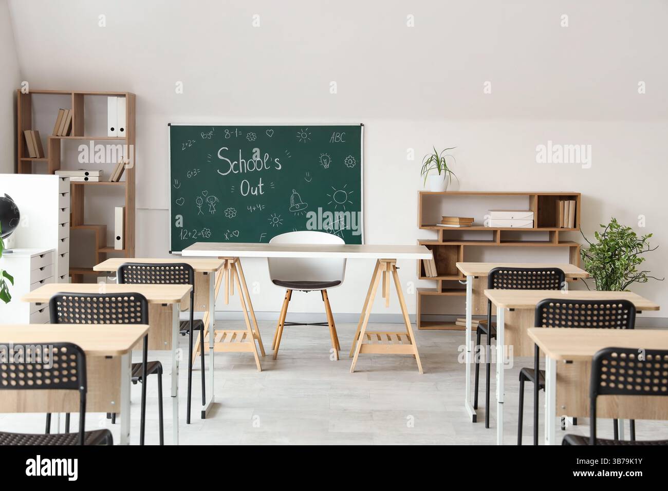 Interior of classroom with blackboard, shelf units and desks. End of ...