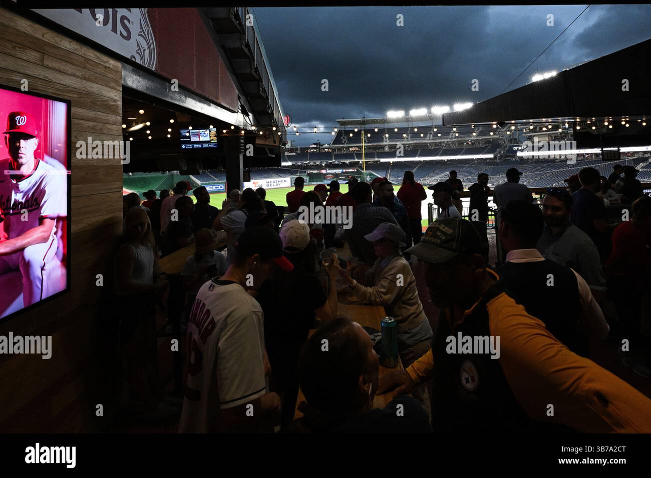 Fans gather in the main concourse as a tarp protects the field during a ...