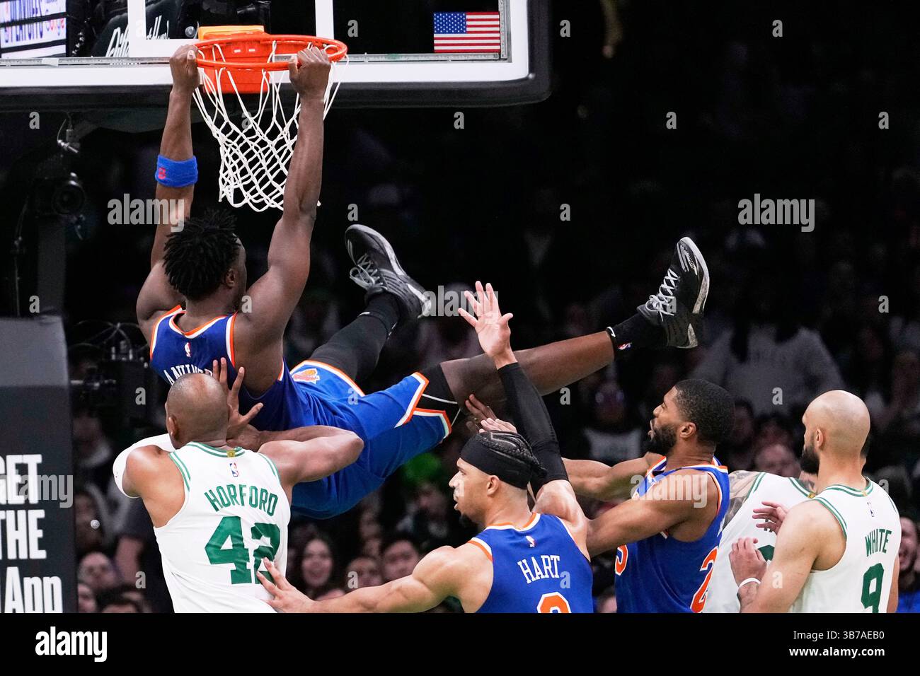 New York Knicks forward OG Anunoby, top, hangs from the rim after ...
