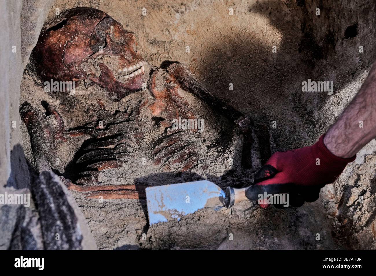 A worker of the German War Graves Commission works on the exhumation of ...