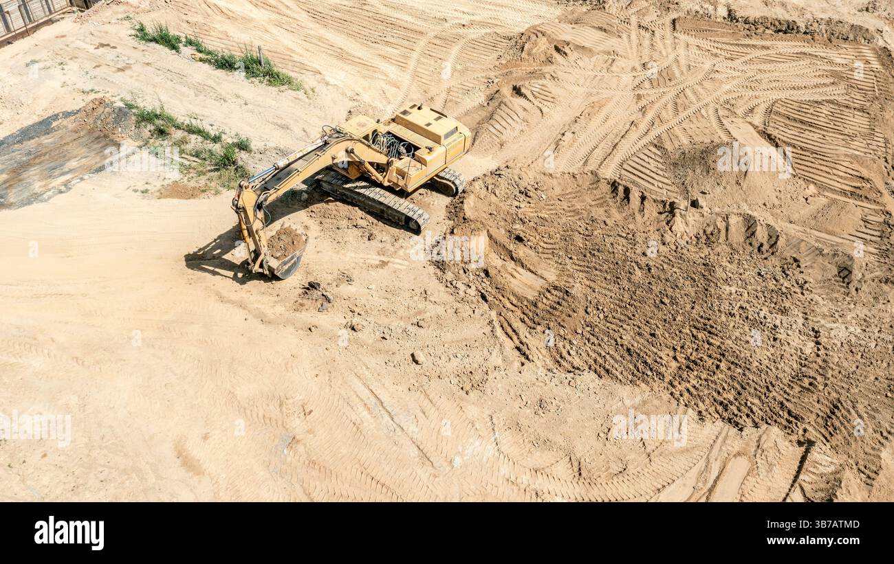 large yellow industrial excavator. construction backhoe on earthworks ...