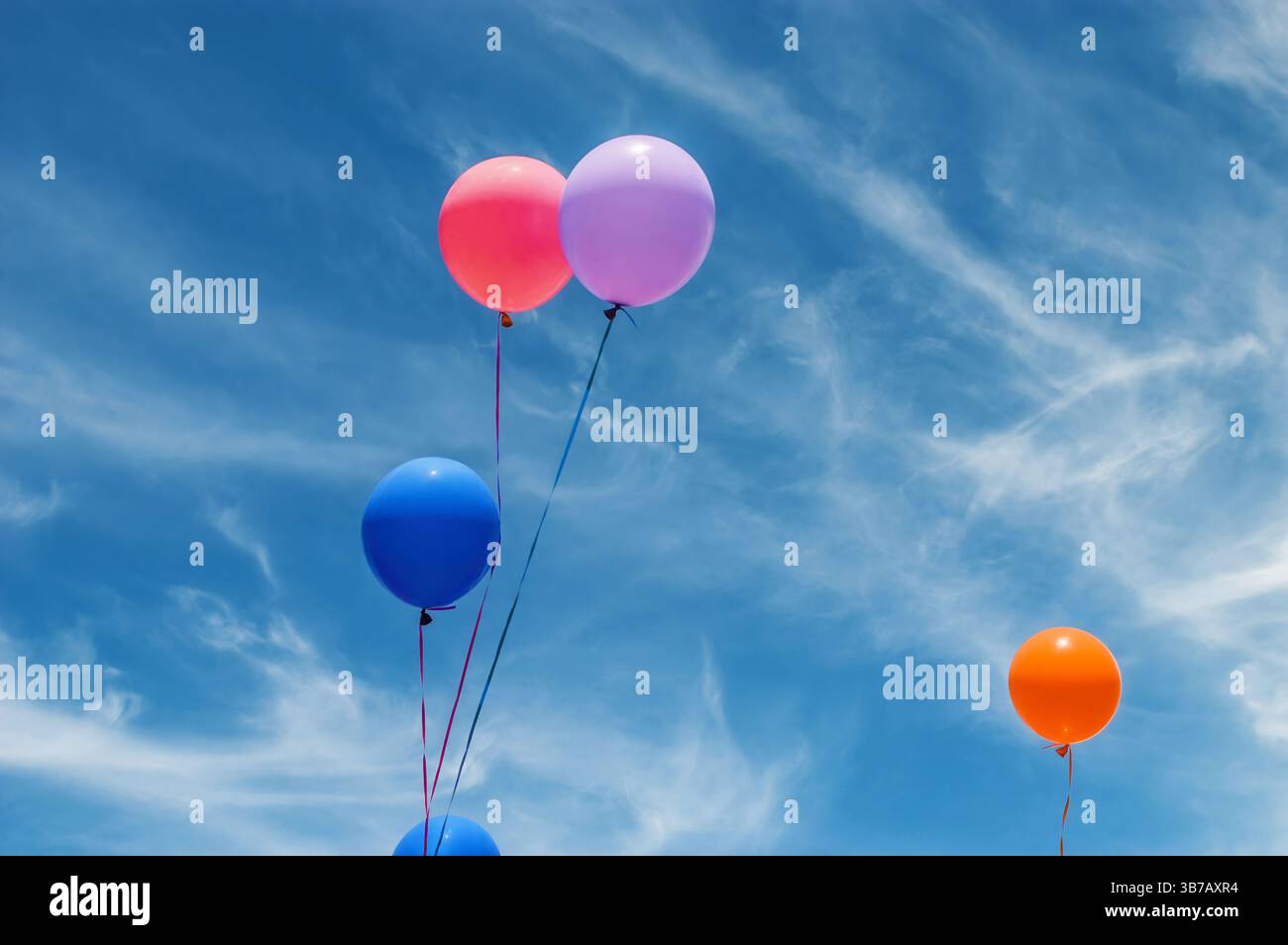 Colourful balloons floating free in a sunny sky Stock Photo - Alamy